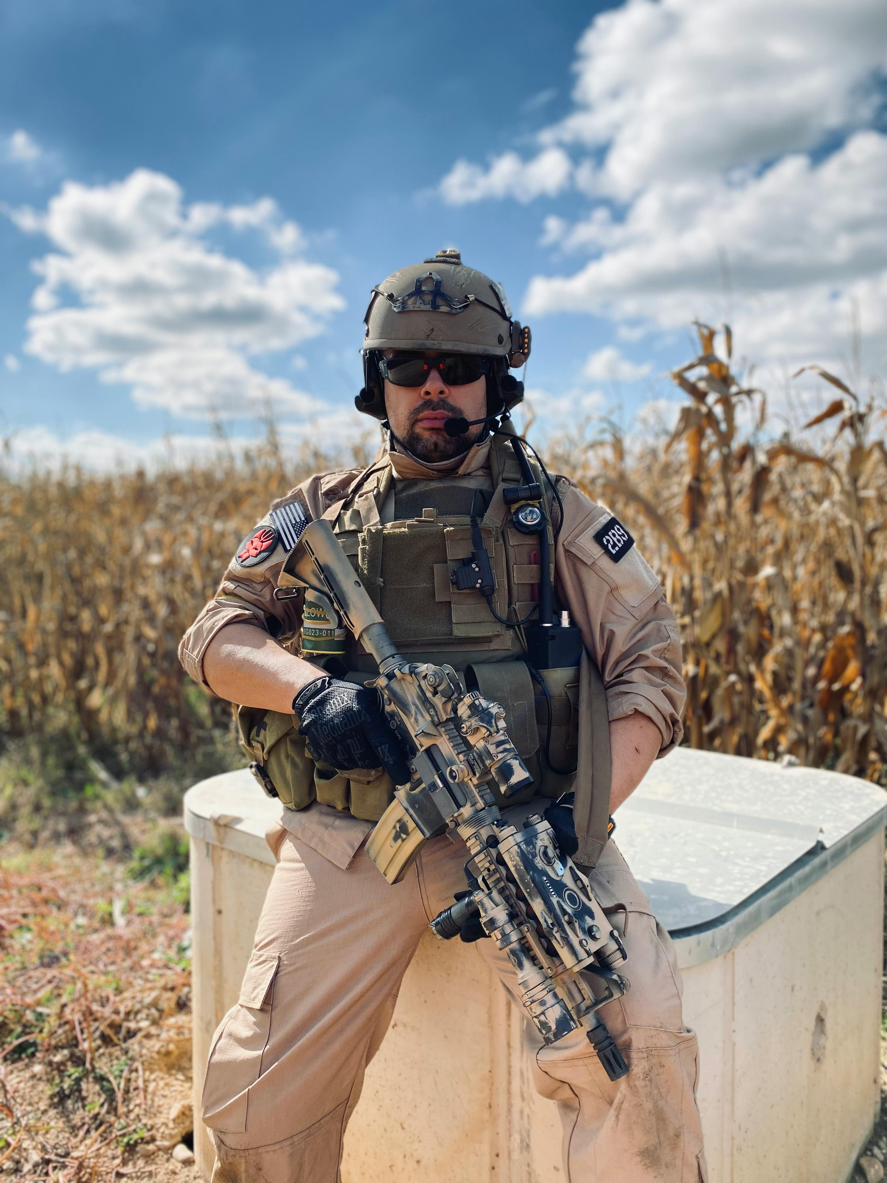 A Man in Military Uniform Holding Black Rifle · Free Stock Photo