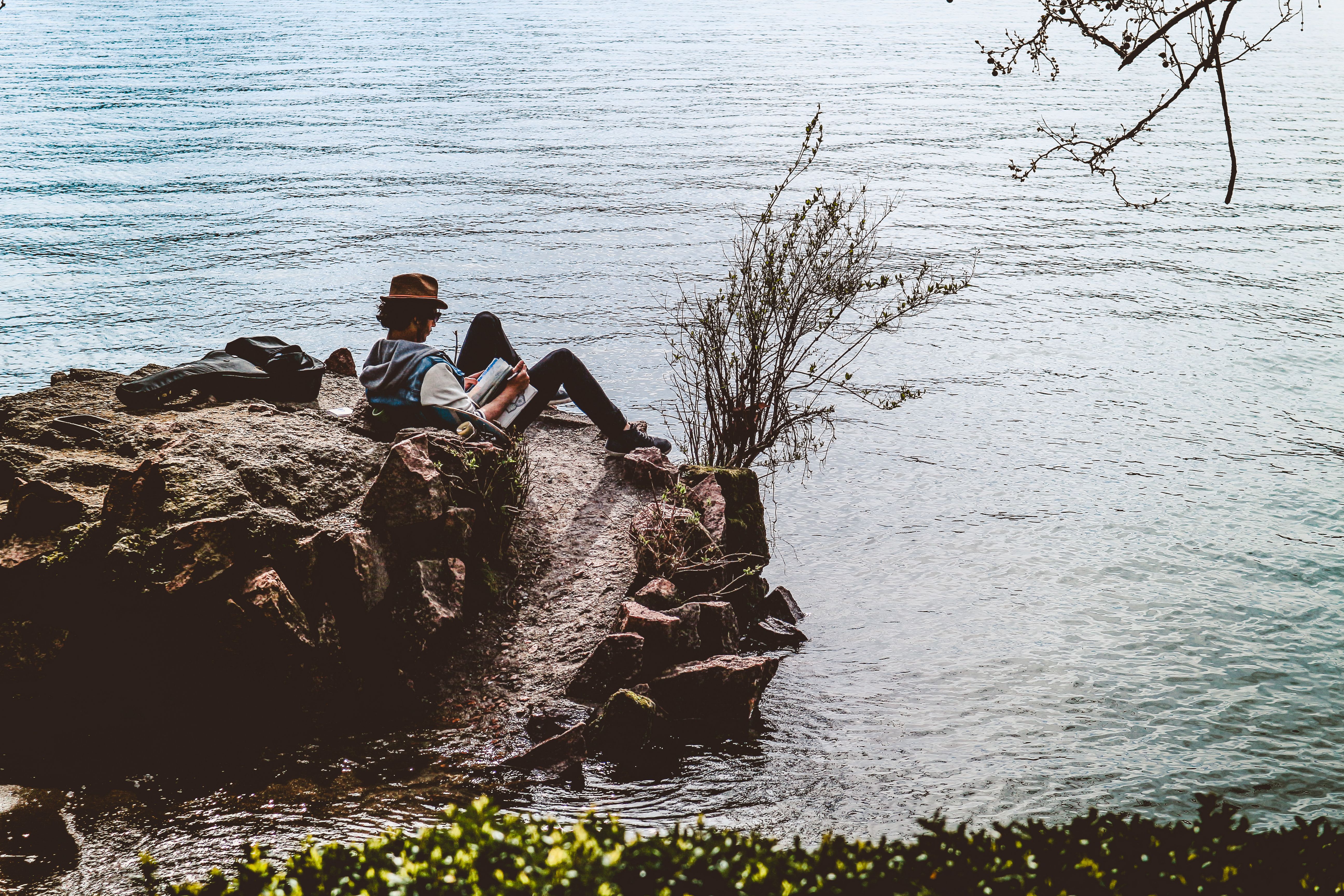 Two Men Sitting on Riverbank · Free Stock Photo