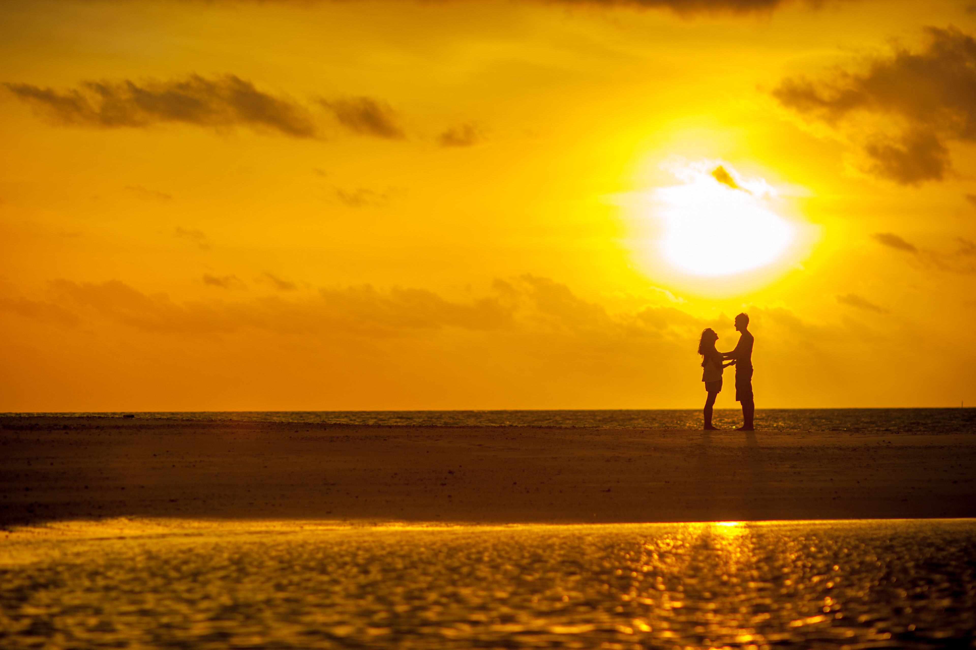 Man and Woman Standing Near Seashore Under Sunset · Free Stock Photo