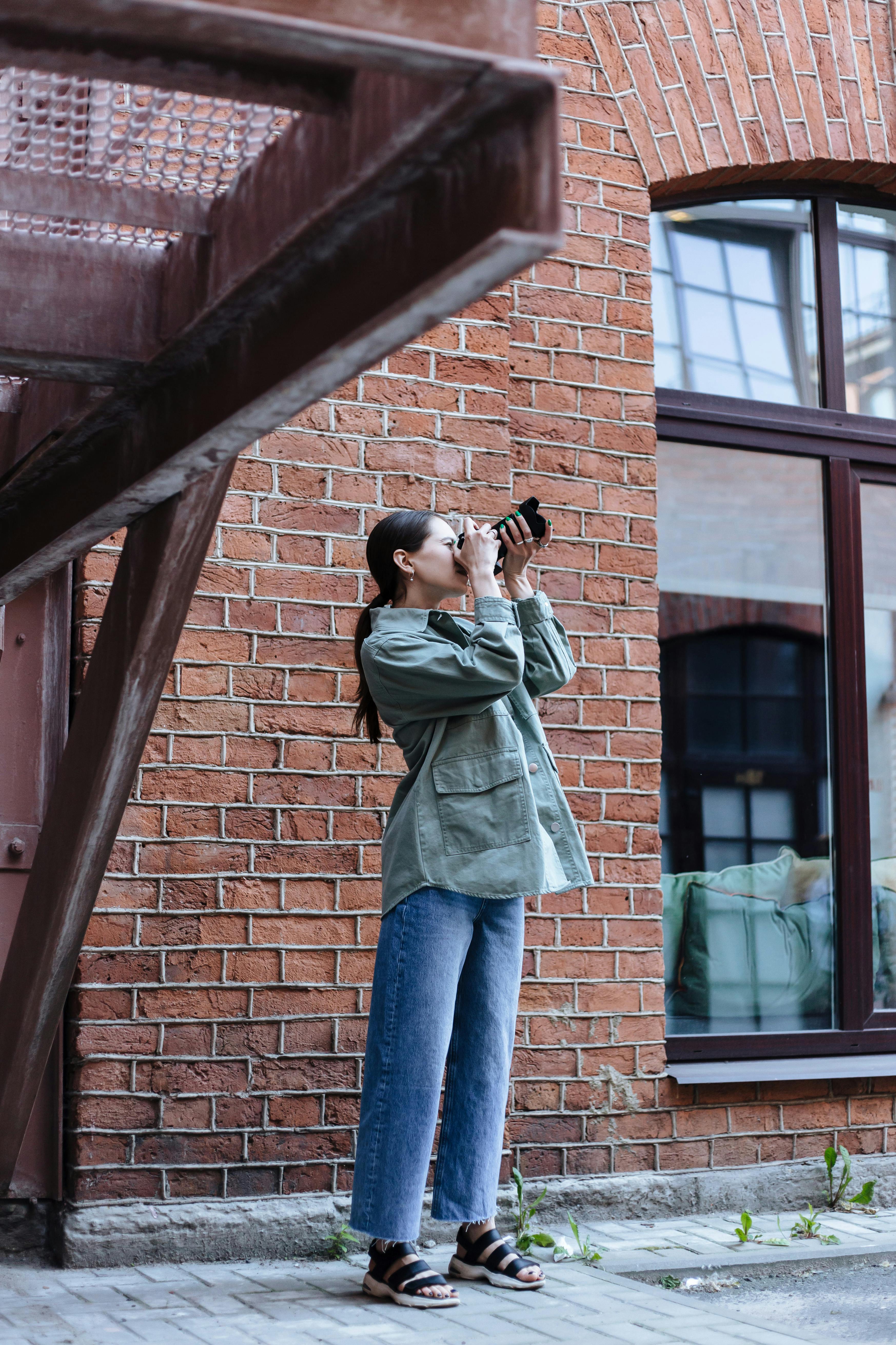 Female Photographer Shooting Photos Standing by Brick Wall of Building ...