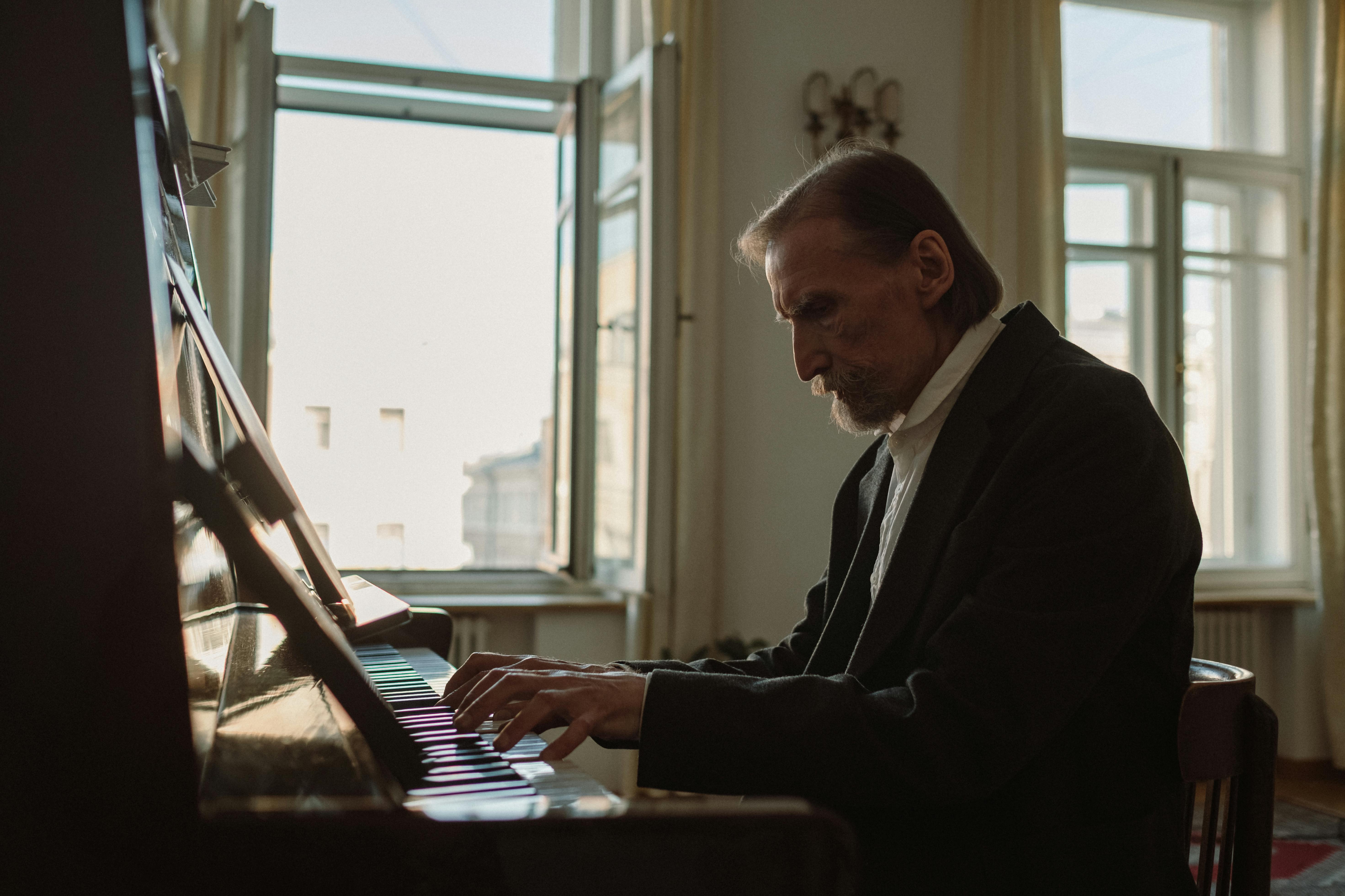 Man Playing Grand Piano On Stage · Free Stock Photo