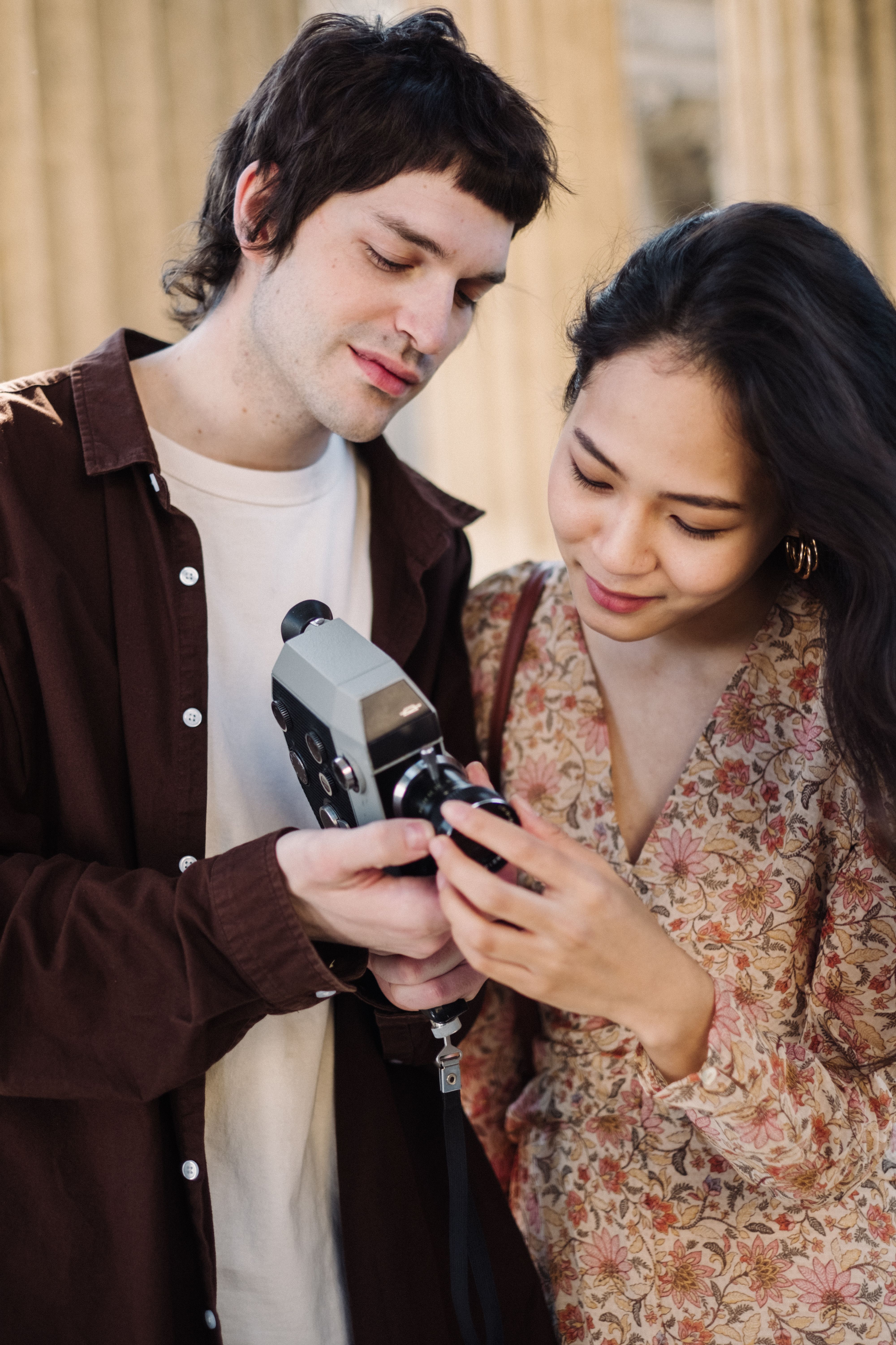 Man and Woman Looking at Analog Camera · Free Stock Photo