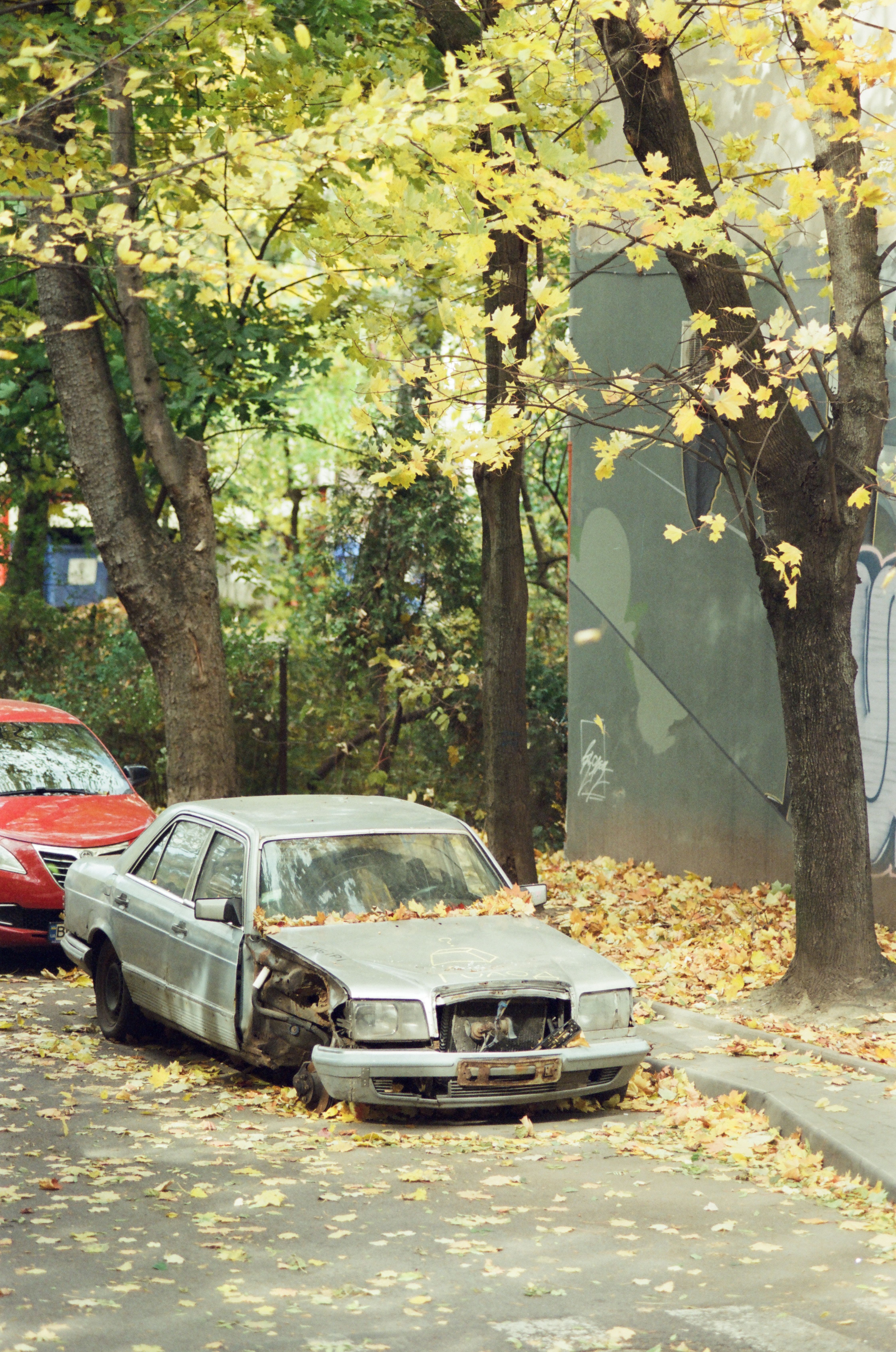 Grayscale Photo of Wrecked Car Parked Outside · Free Stock Photo