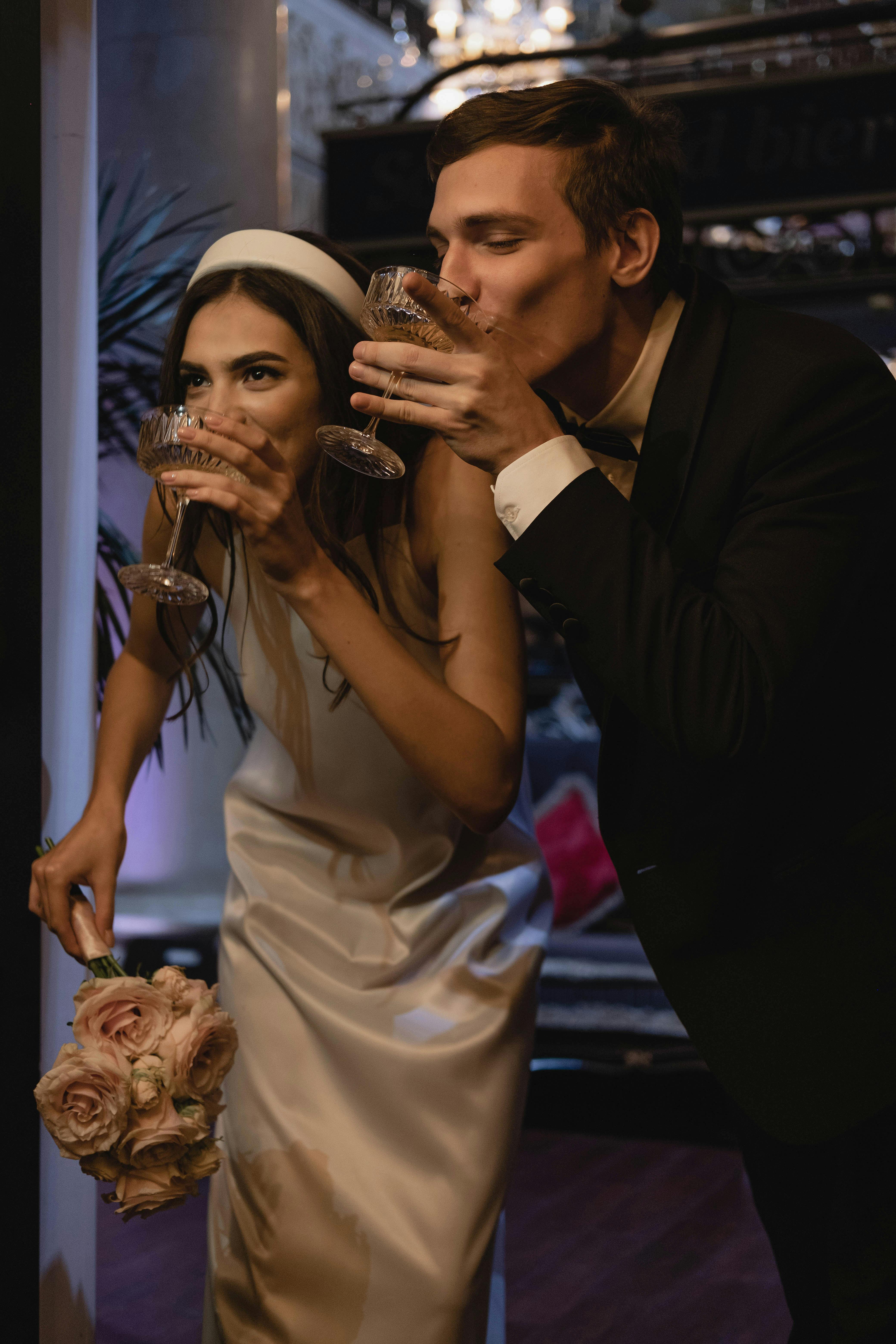 Photo of a Couple Popping a Champagne Bottle Together · Free Stock Photo