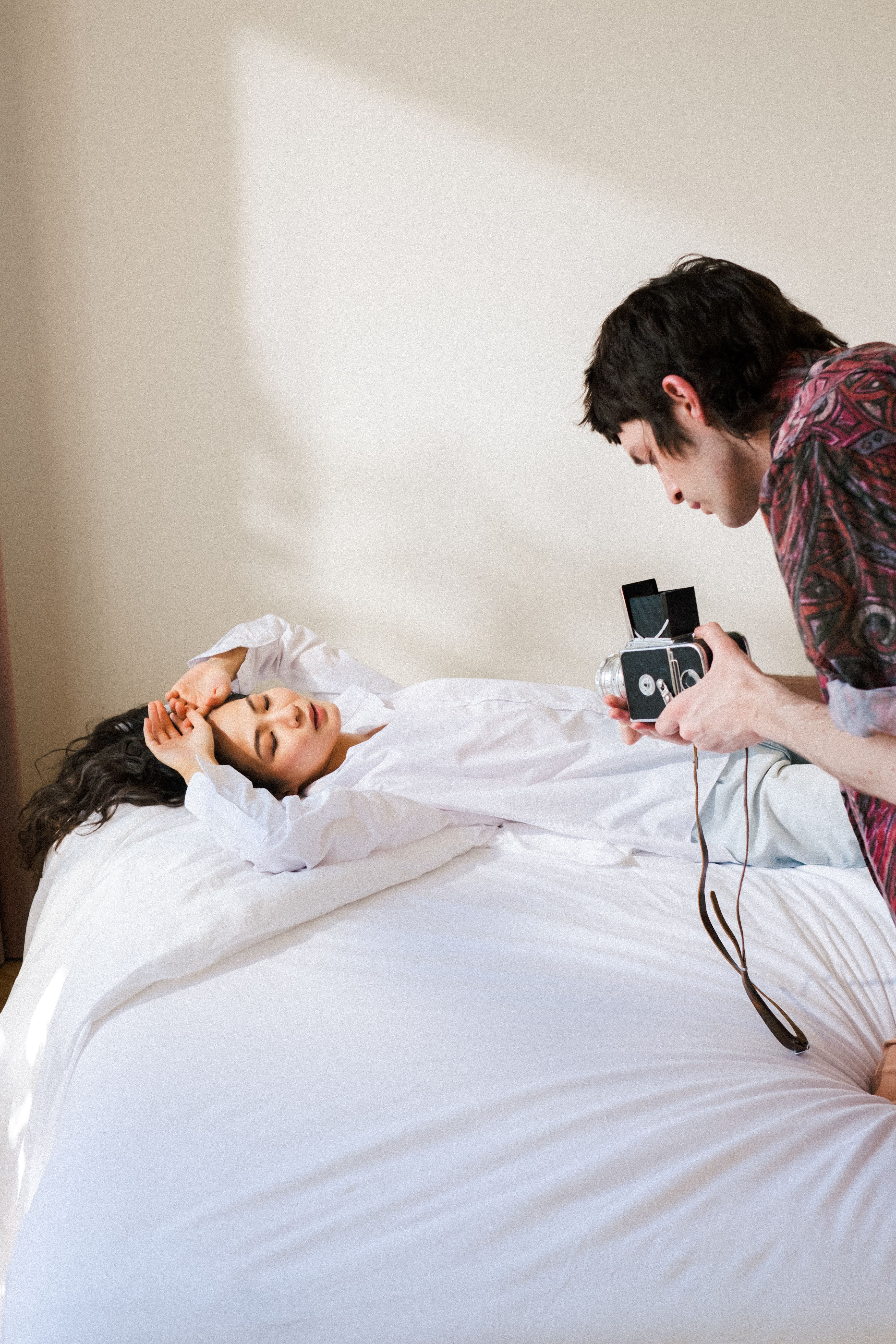 Man Filming Woman on Bed · Free Stock Photo
