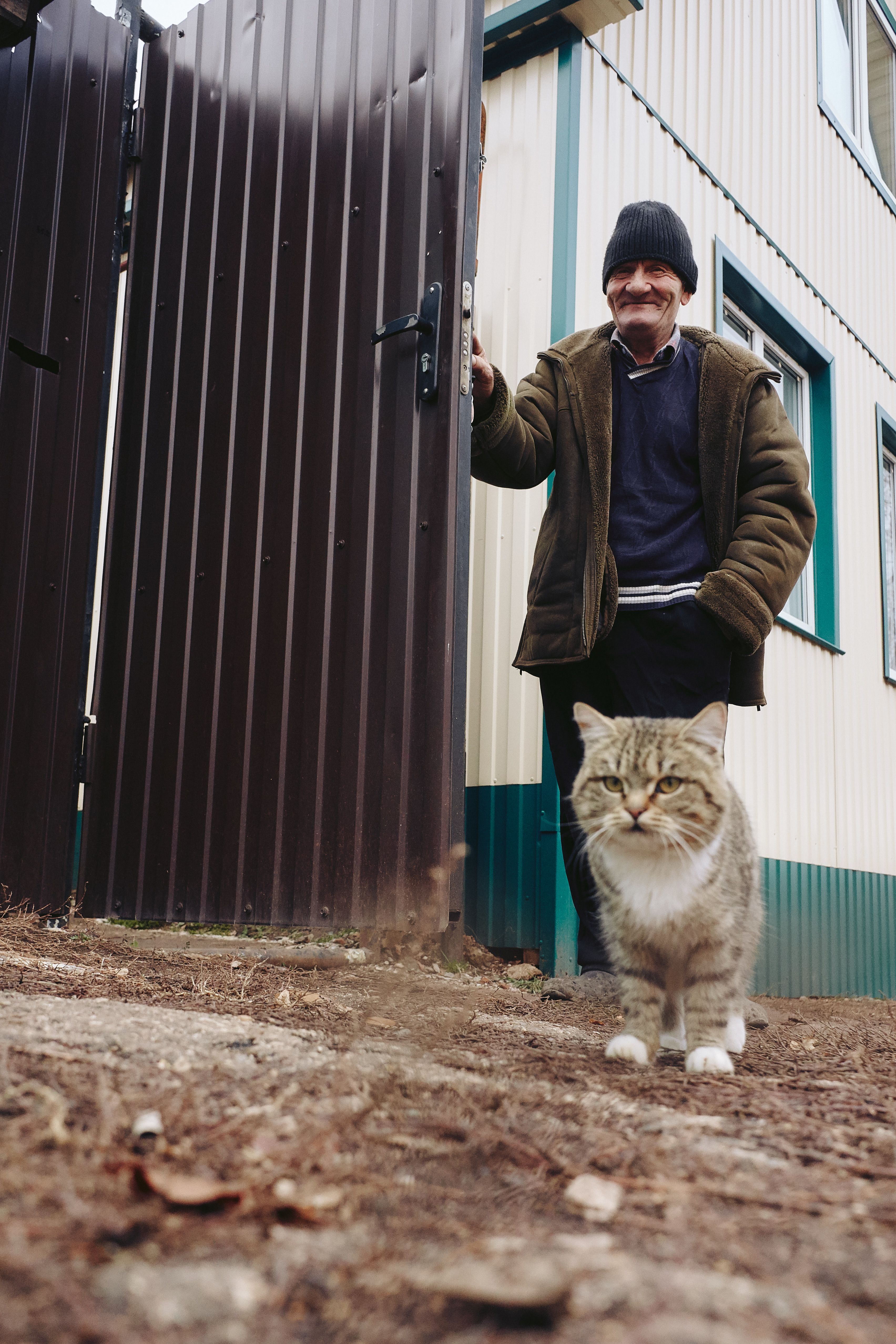 Man Standing the Gate near a Cat · Free Stock Photo