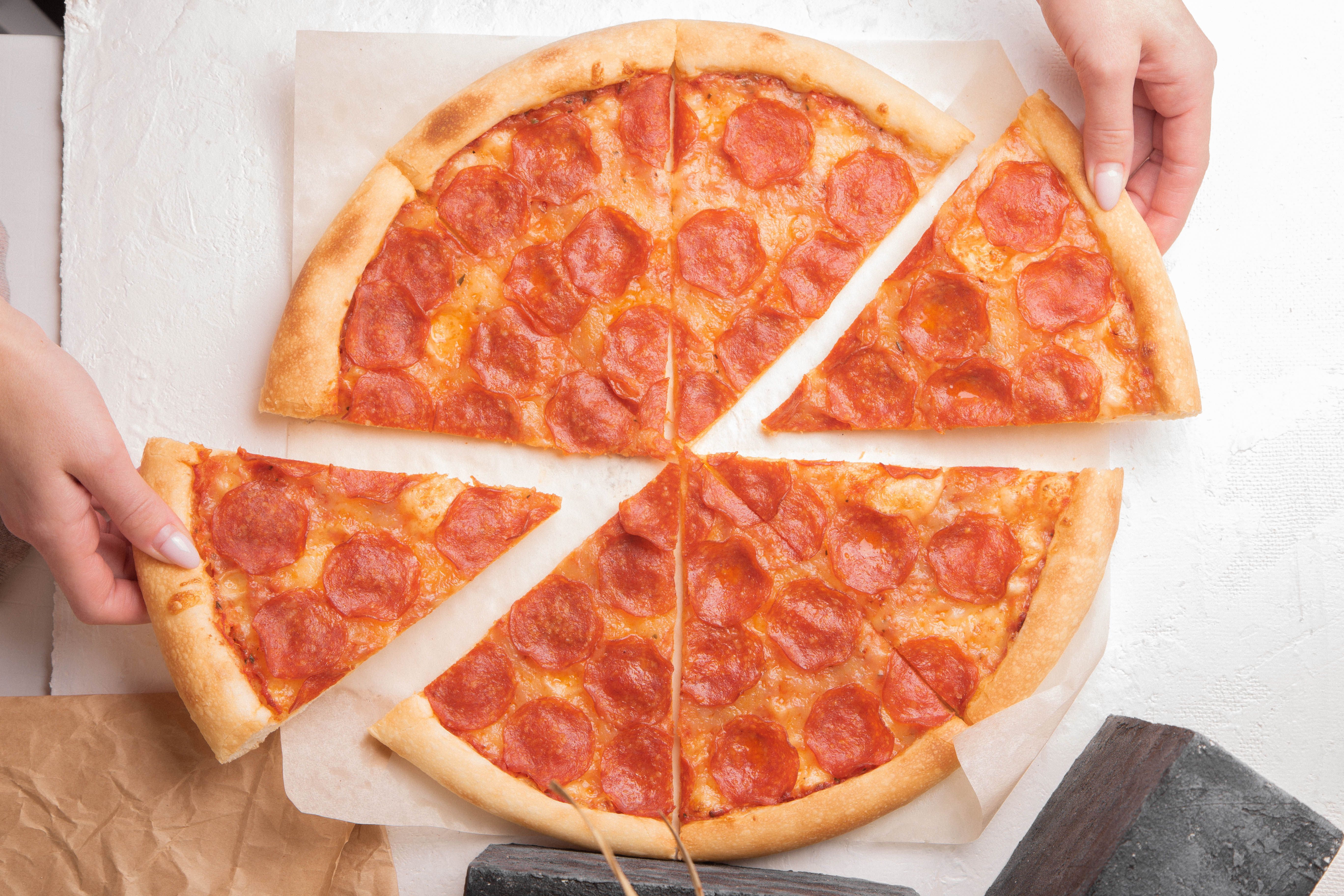 Getting Slices of Pepperoni Pizza · Free Stock Photo