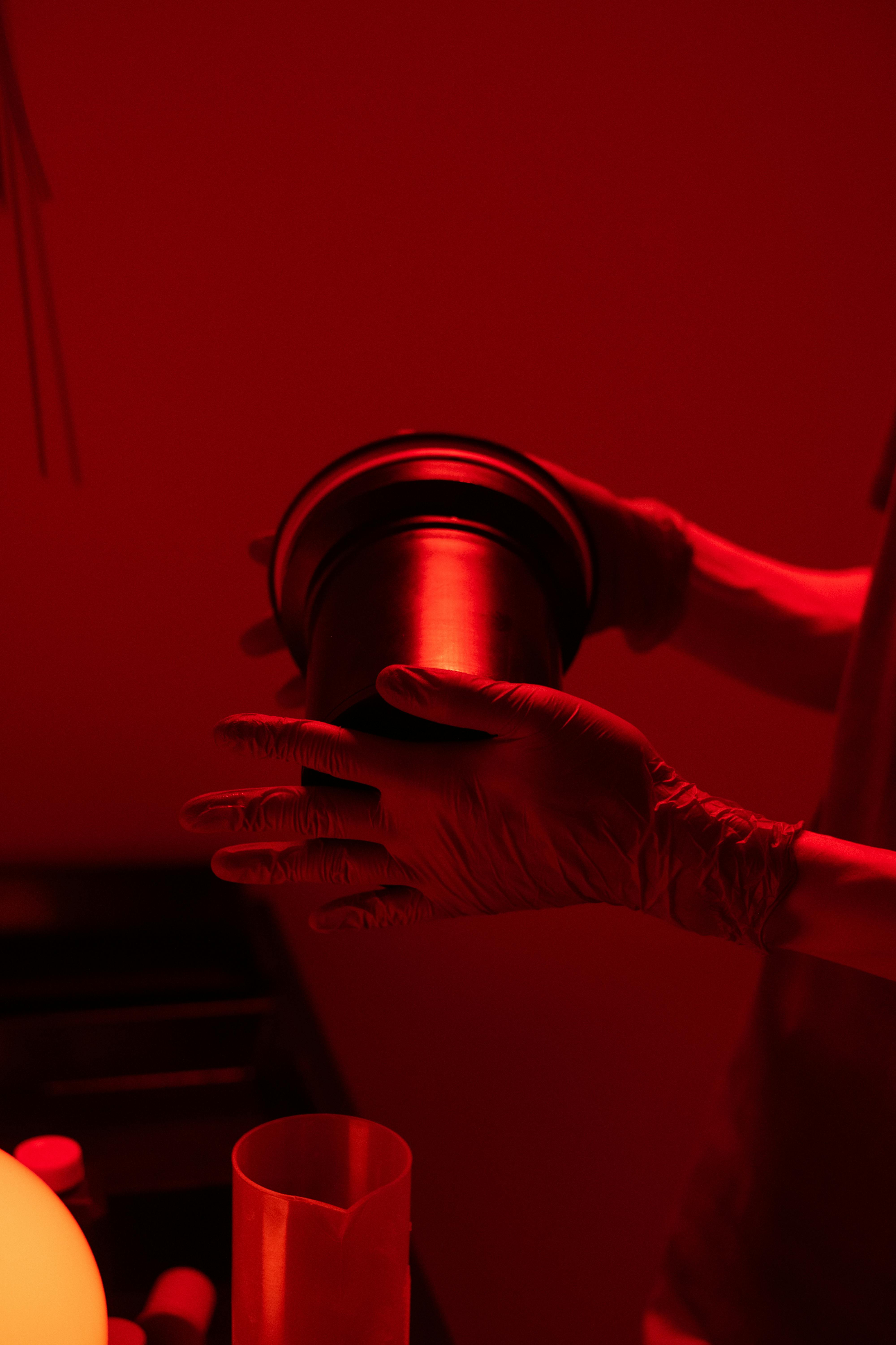 Man Holding Lens in Red Light · Free Stock Photo
