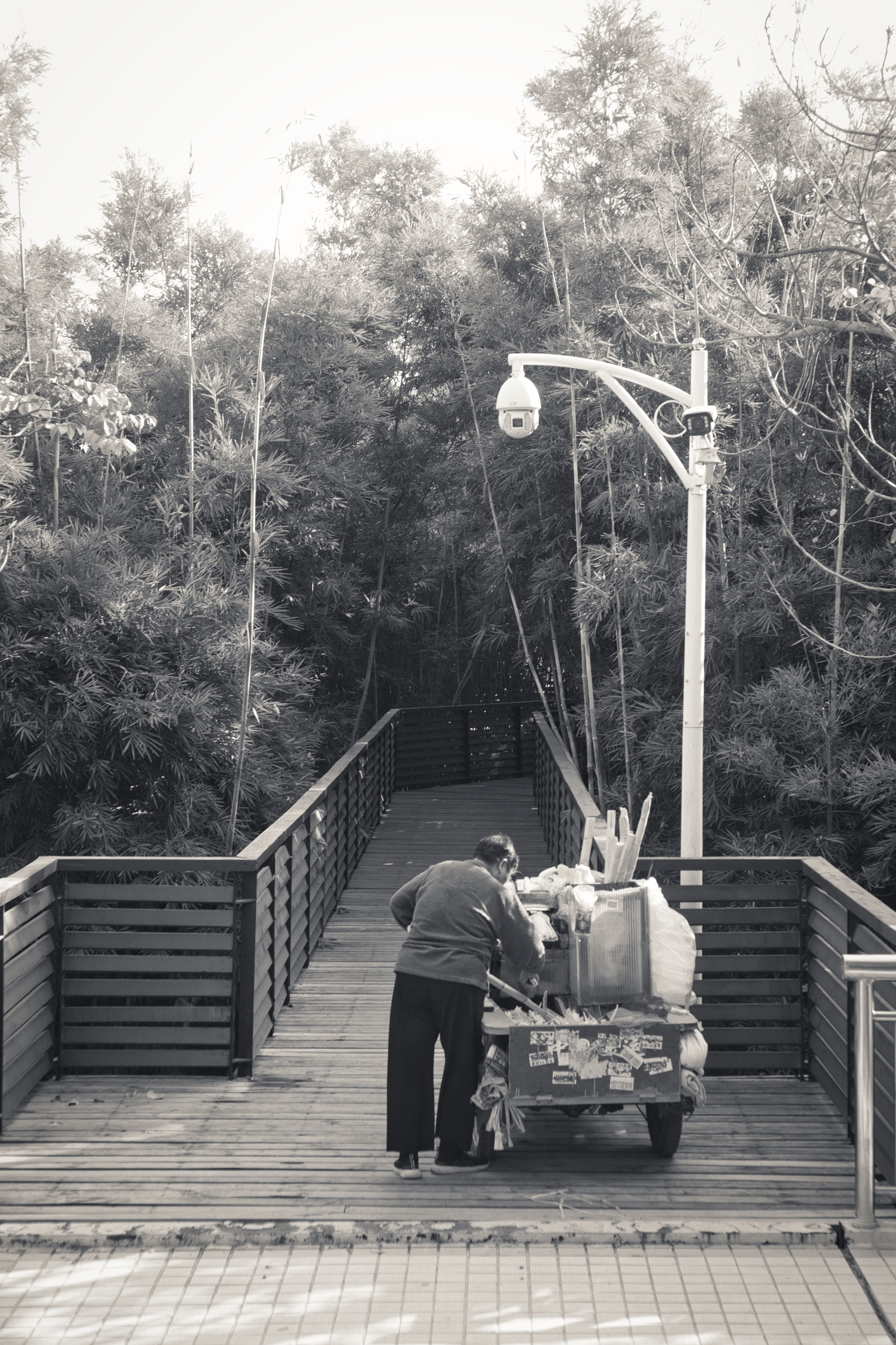 Monochrome Photo of People Crossing A Bridge · Free Stock Photo