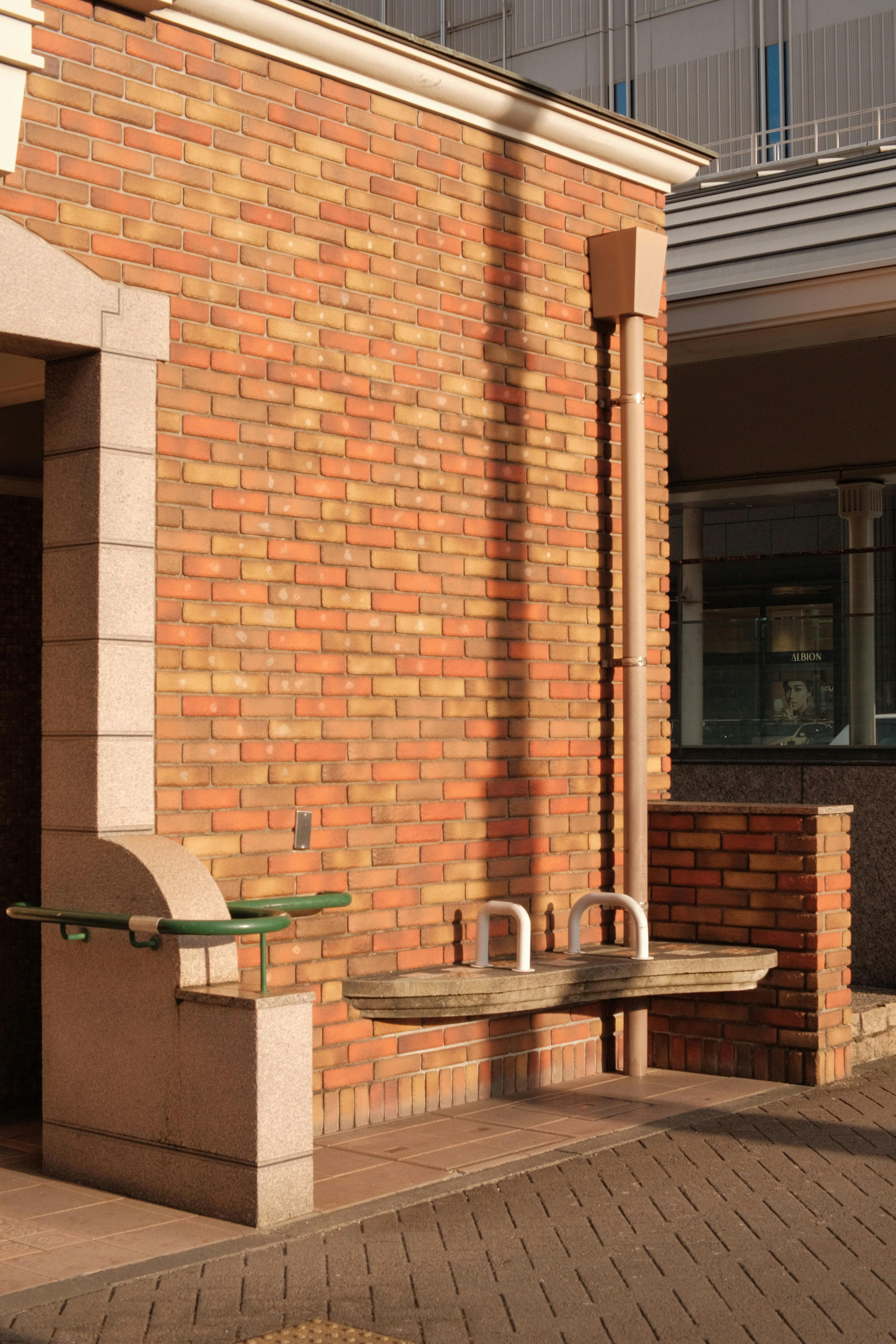 Concrete Bench on a Brick Wall · Free Stock Photo