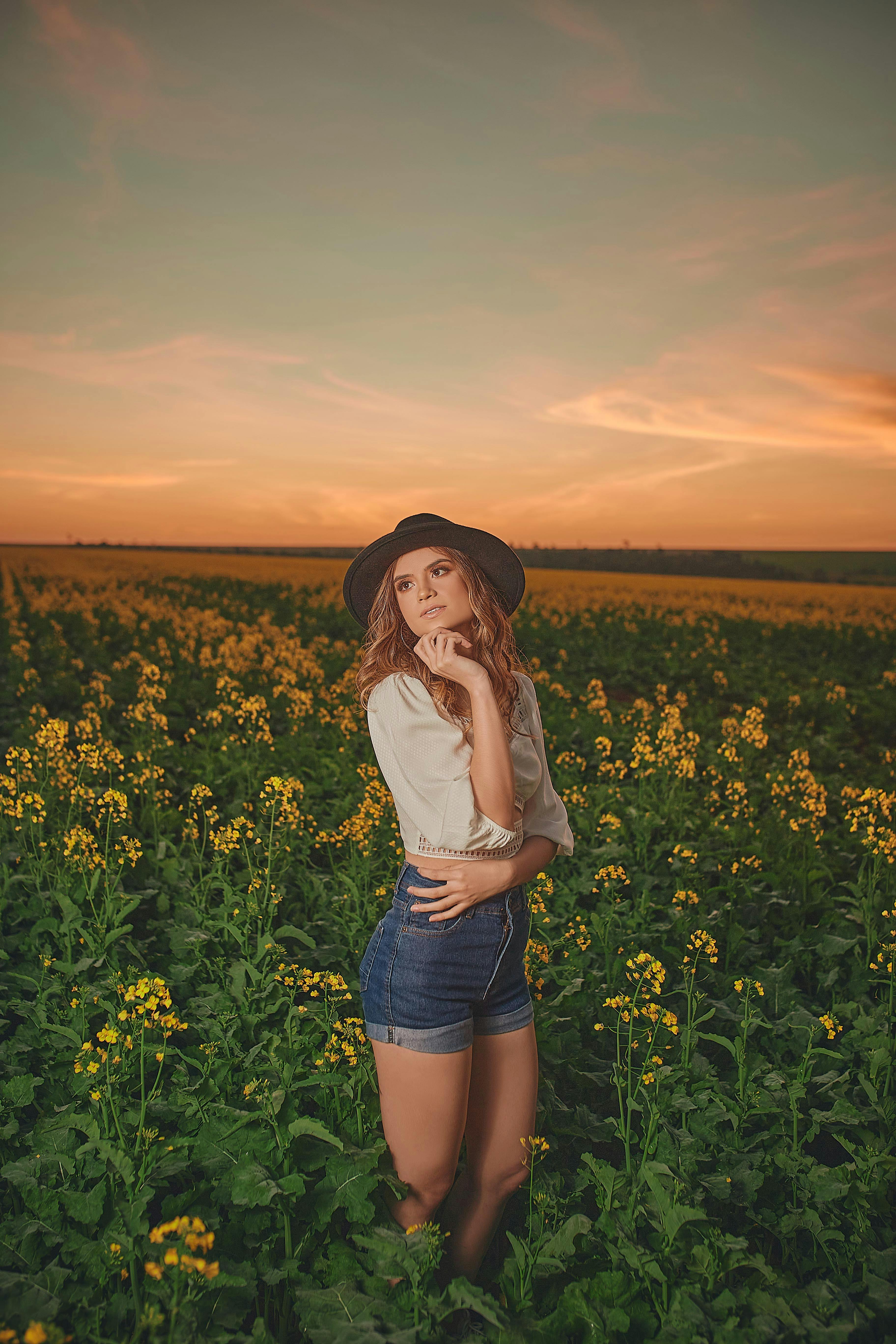 A Woman Posing in Denim Shorts and a Yellow Top · Free Stock Photo