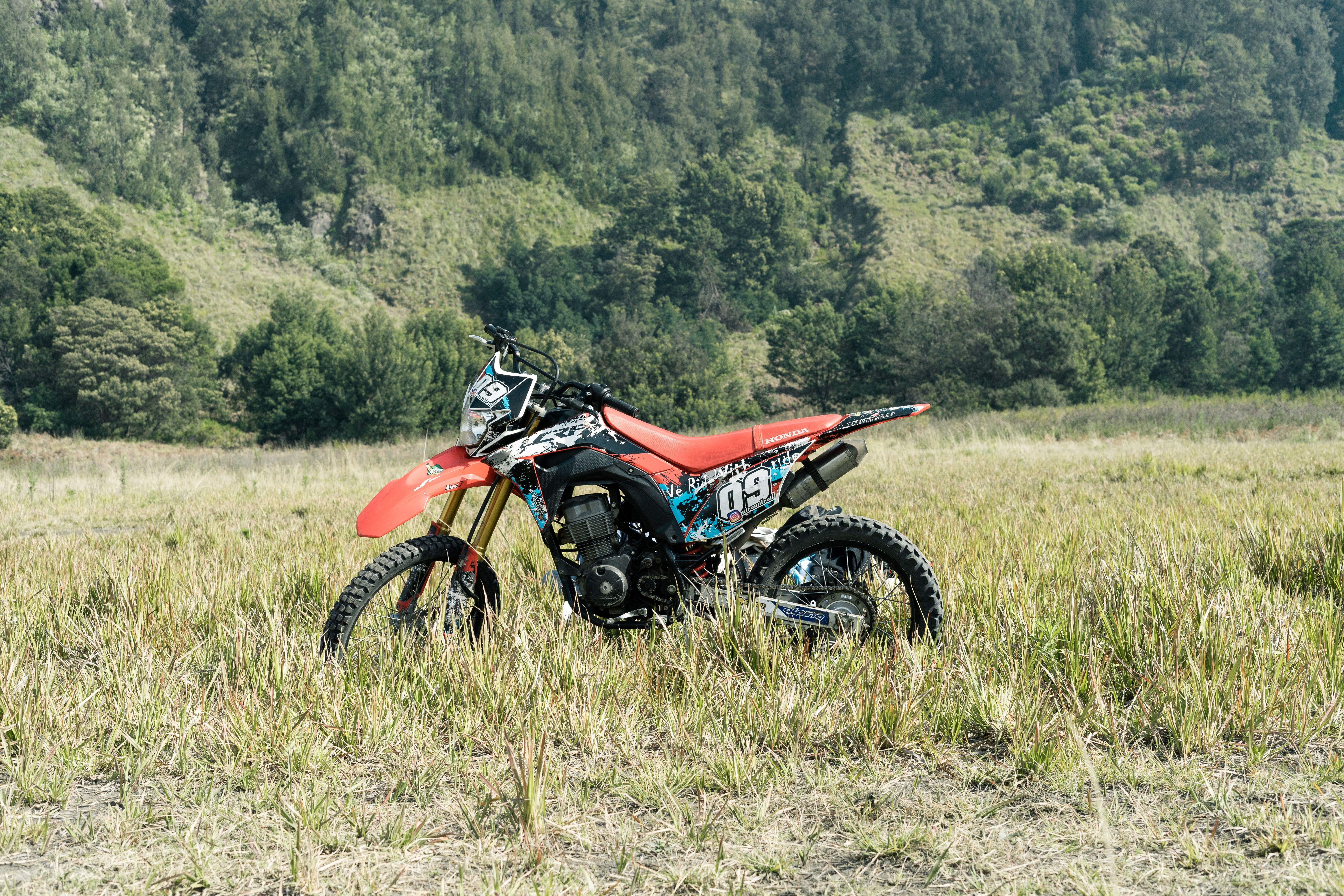 Red and Black Motocross Dirt Bike on Green Grass Field · Free Stock Photo