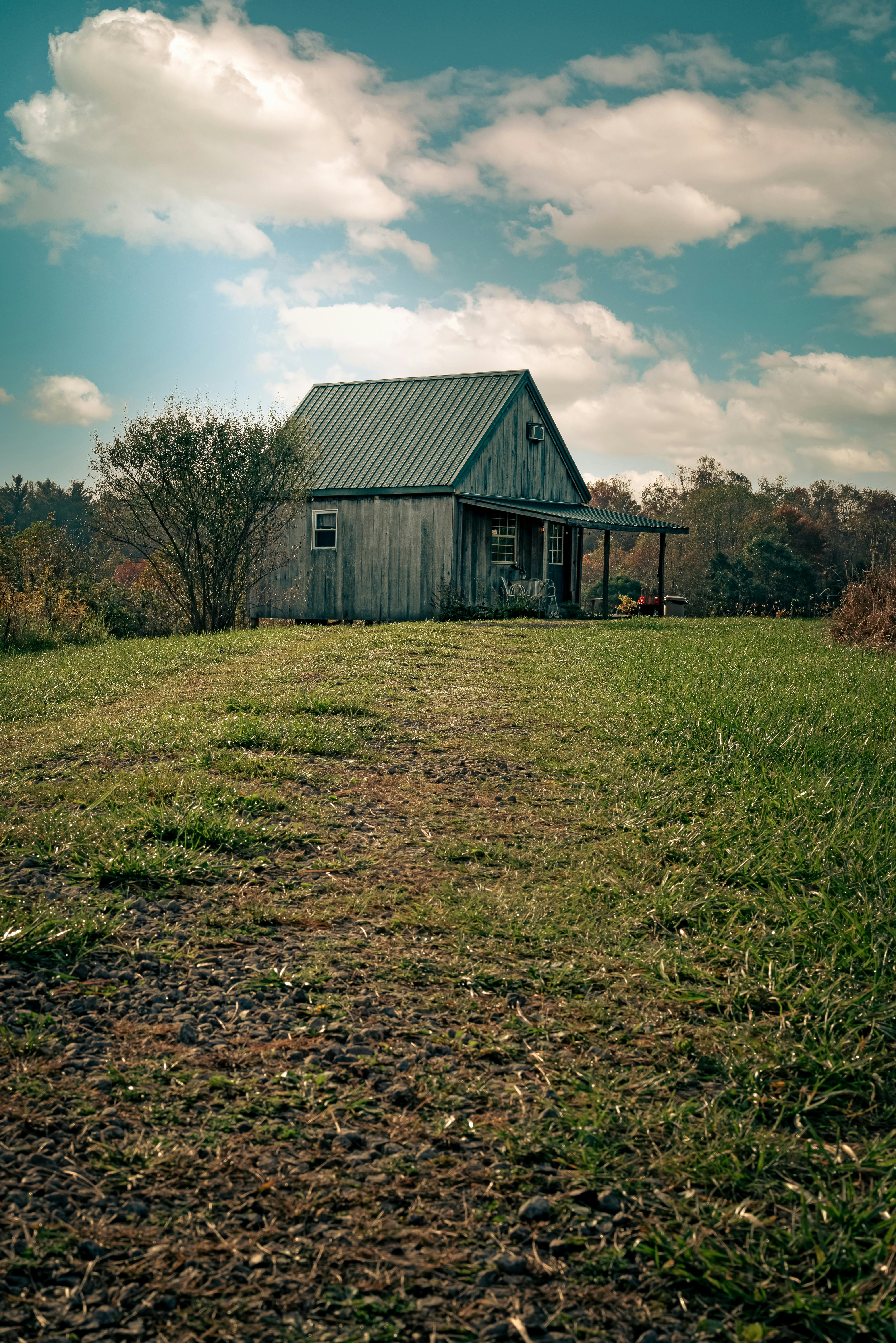 Brown House in the Middle of Green Open Field Surrounded With Trees ...