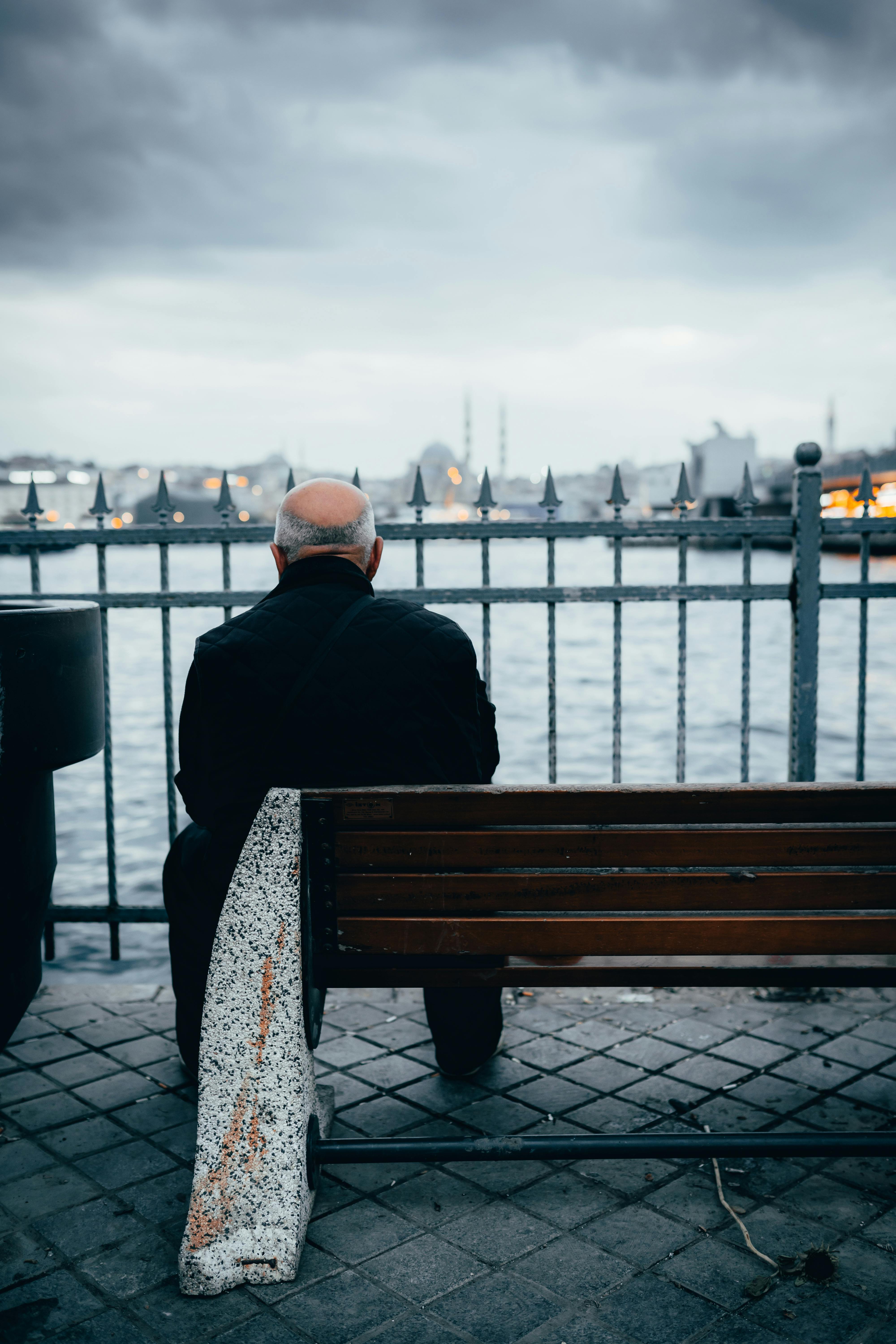 Man Sitting on Bench on Waterfront · Free Stock Photo