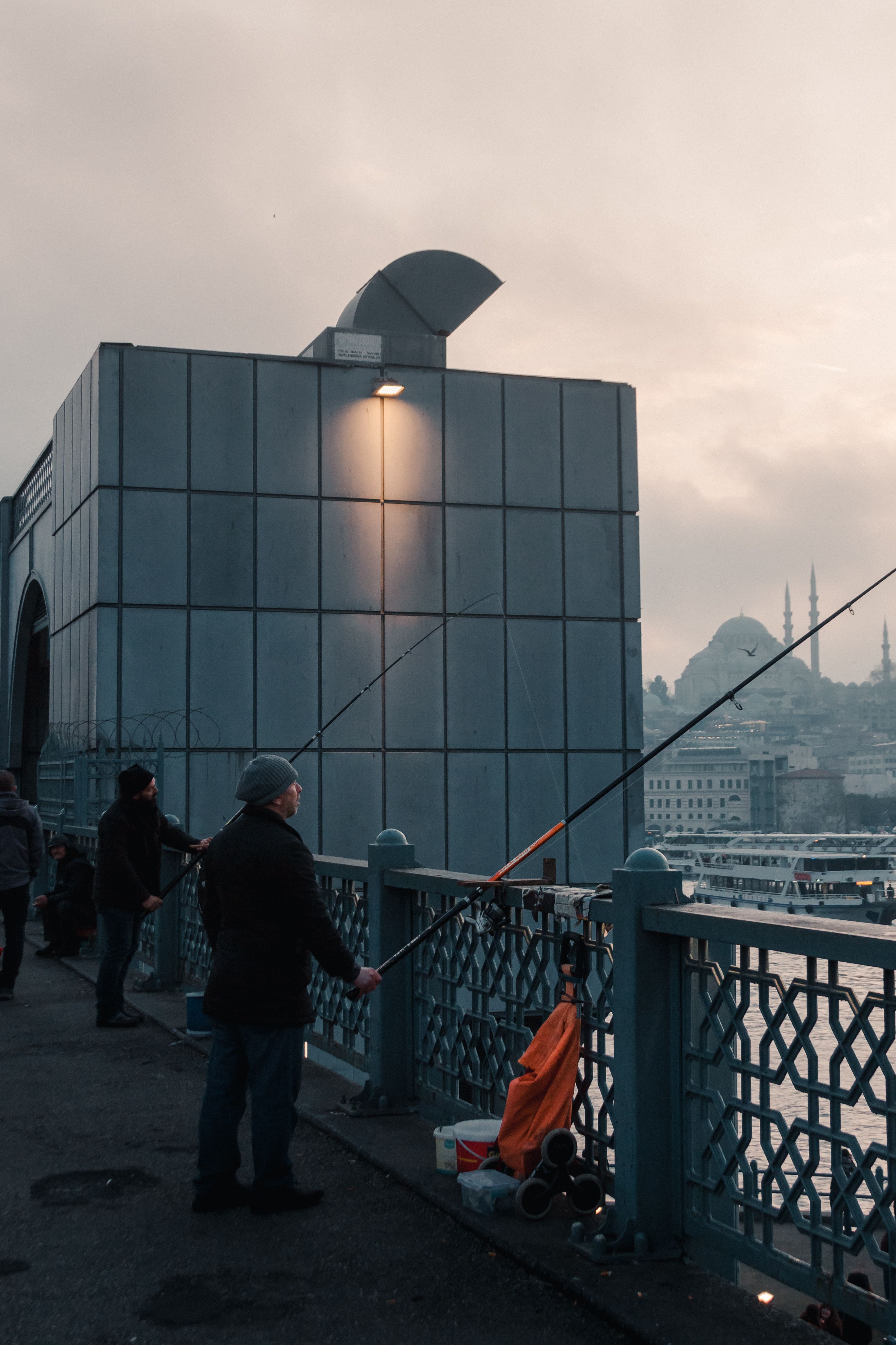 Man Fishing from Behind a Harbor Railing · Free Stock Photo