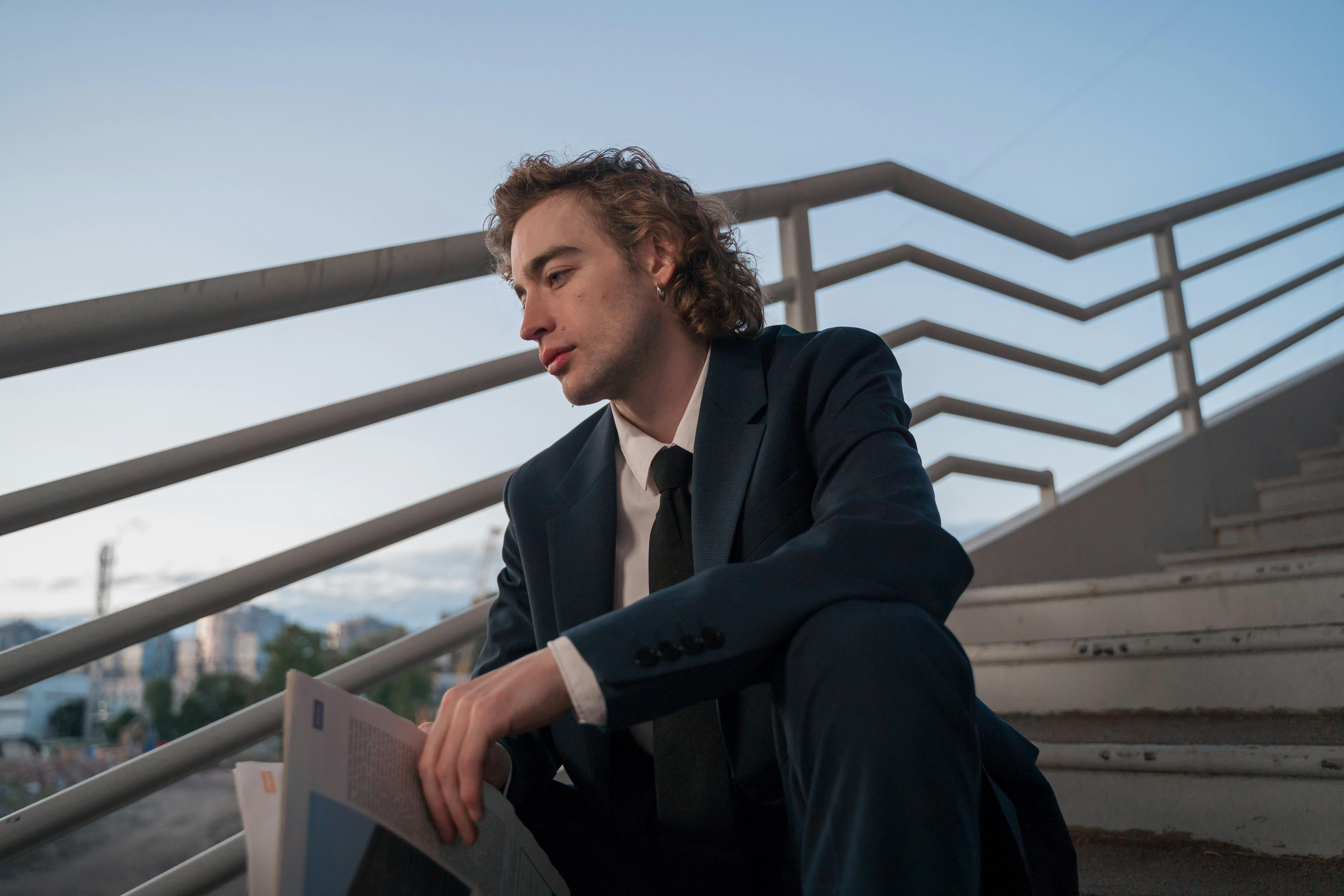 Photo of a Man in a Blue Suit Sitting on the Stairs · Free Stock Photo