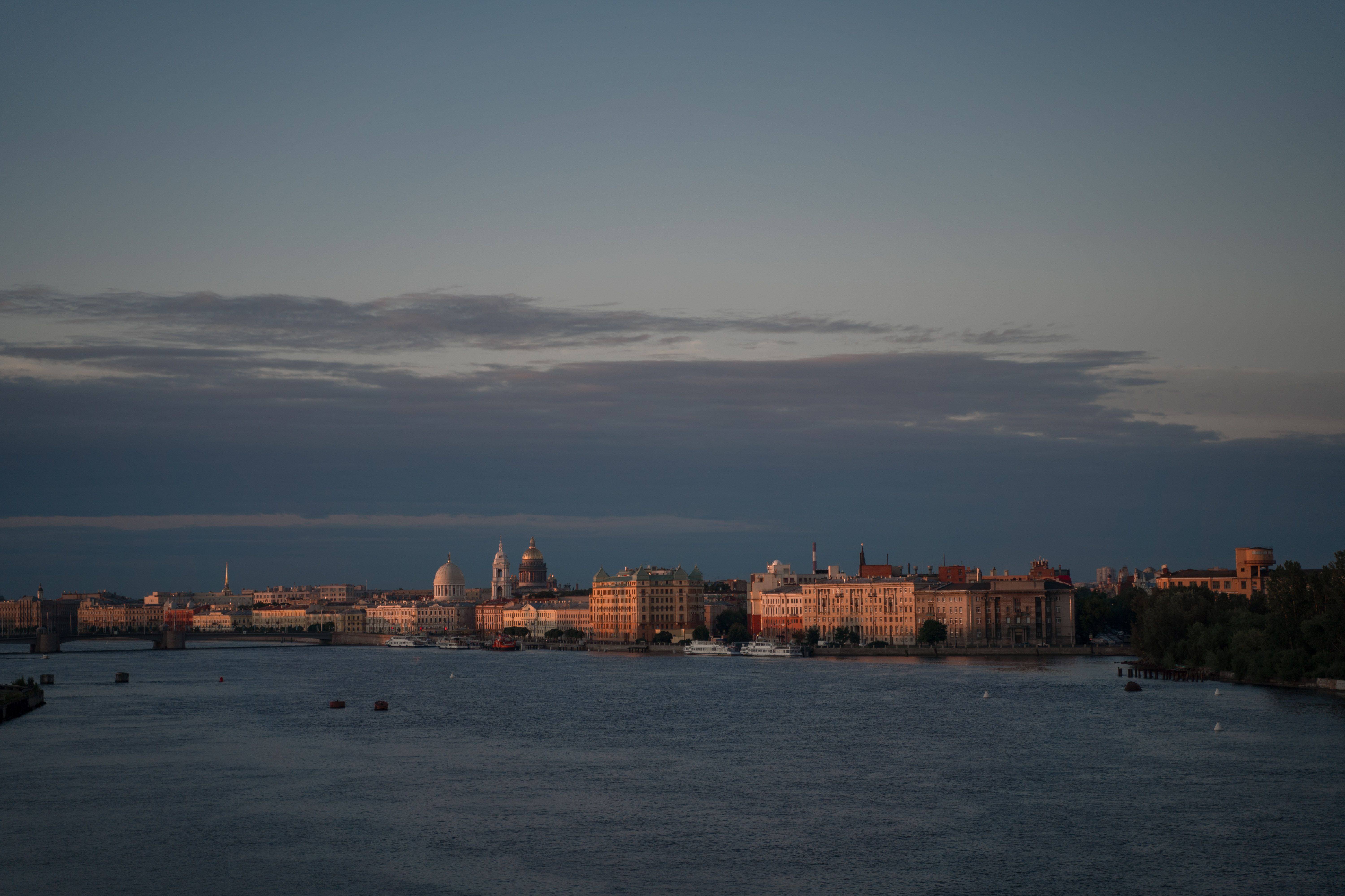 Skyline of a City seen from across a River at Sunset · Free Stock Photo