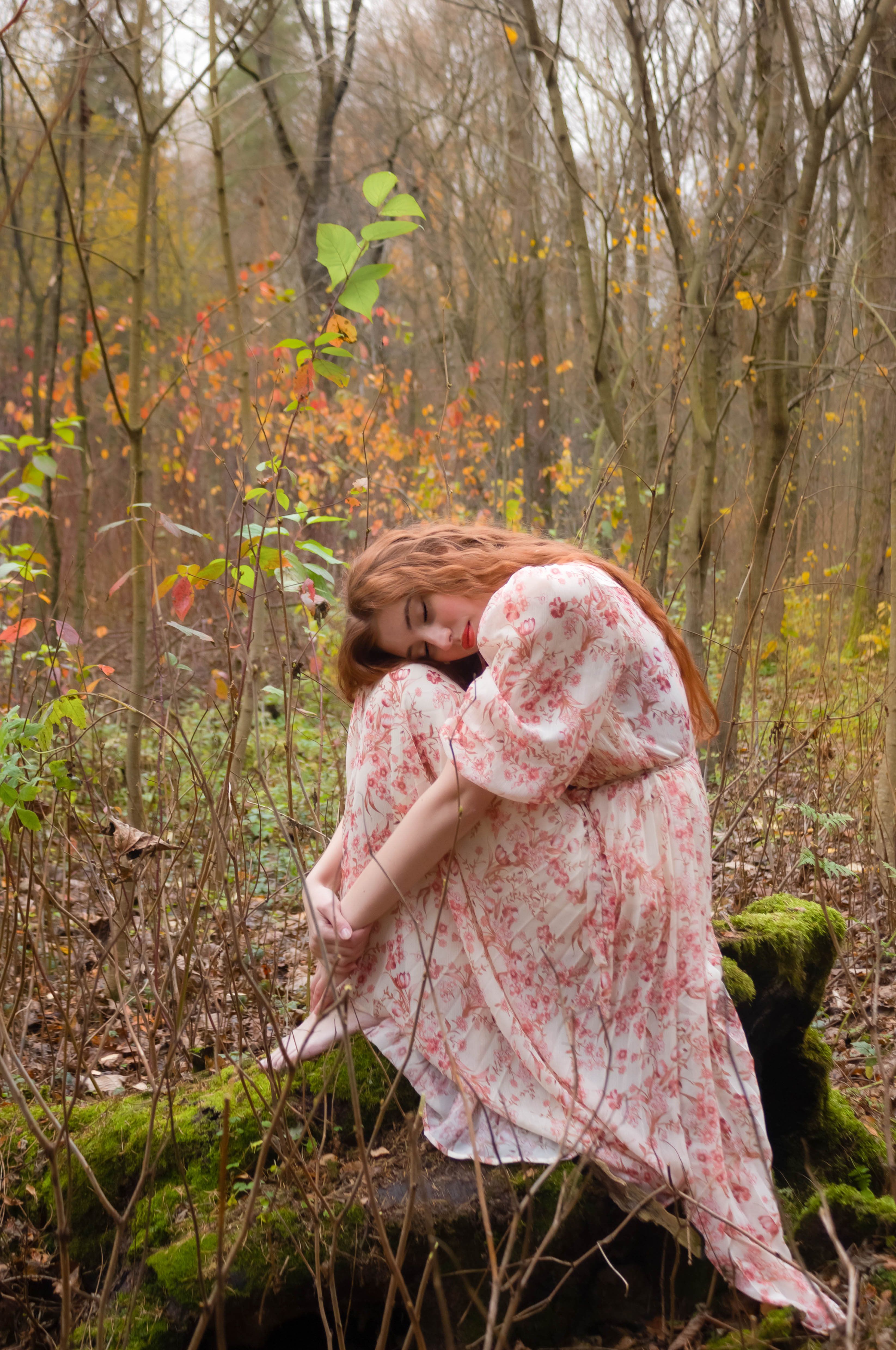 Woman in a Floral Dress Sitting on a Mossy Surface · Free Stock Photo