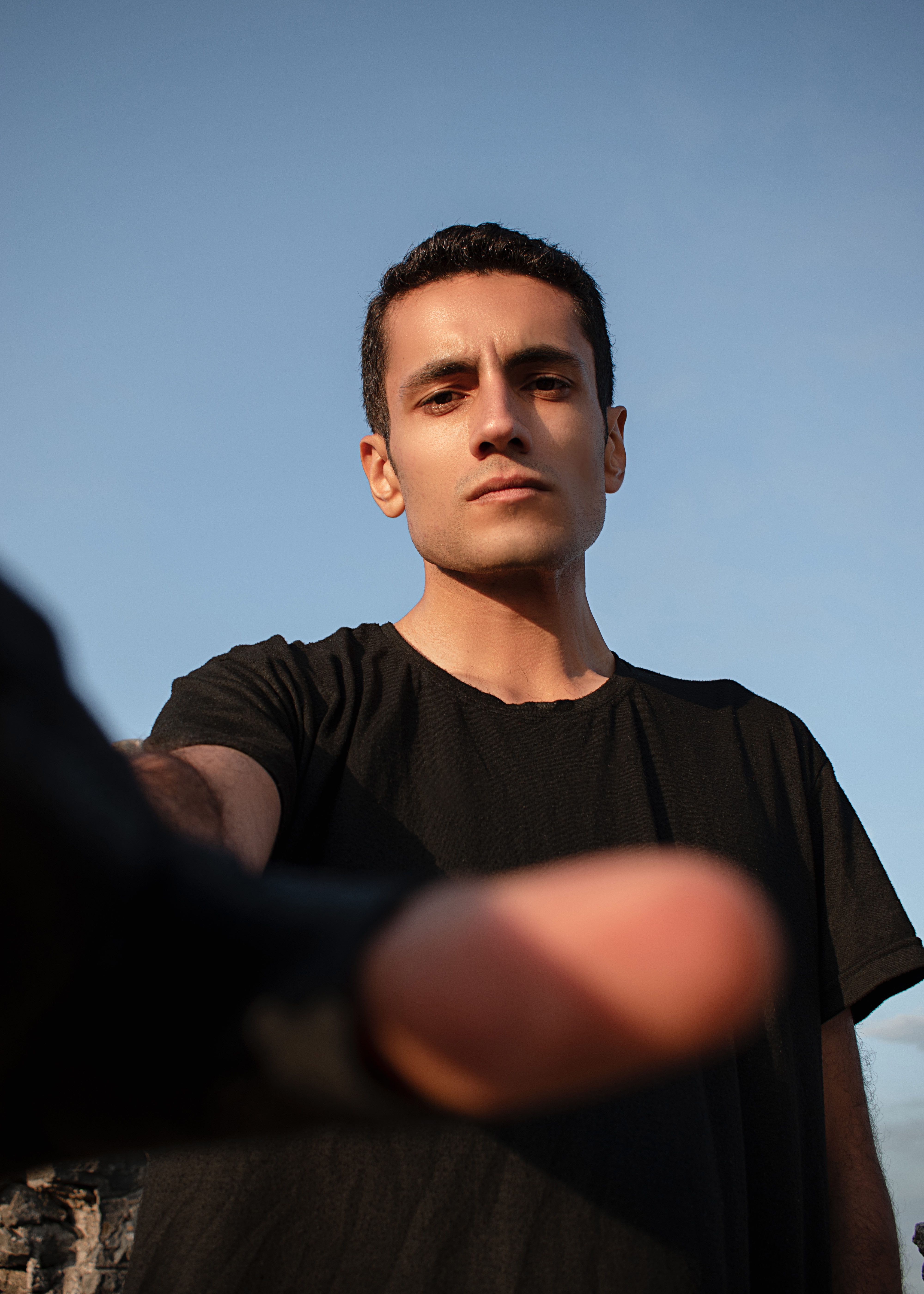 Close-up of a Man Reaching His Arm toward the Light · Free Stock Photo