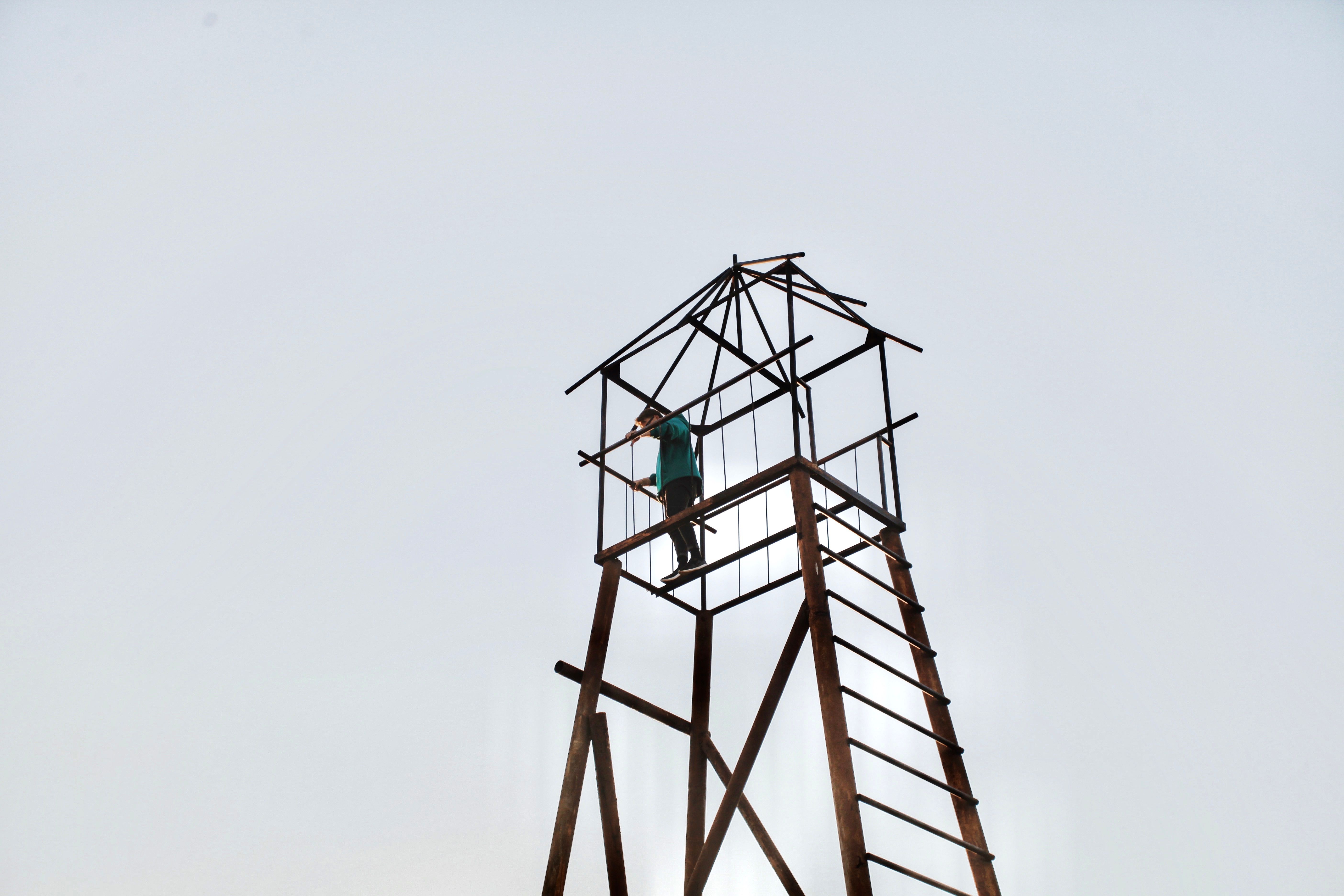 A Man Standing on a Metal Tower · Free Stock Photo