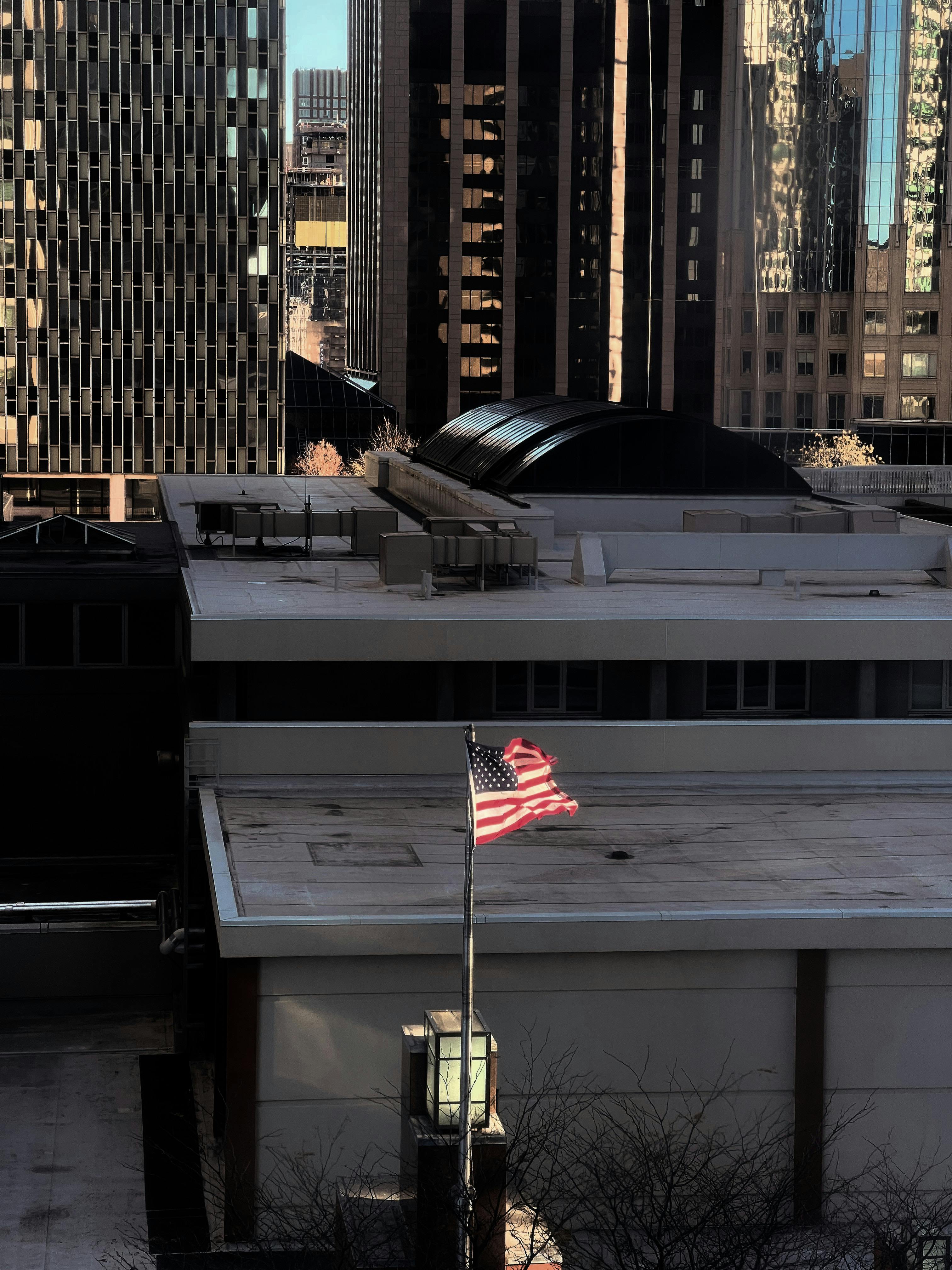 American Flag Flying above Roof of Building · Free Stock Photo