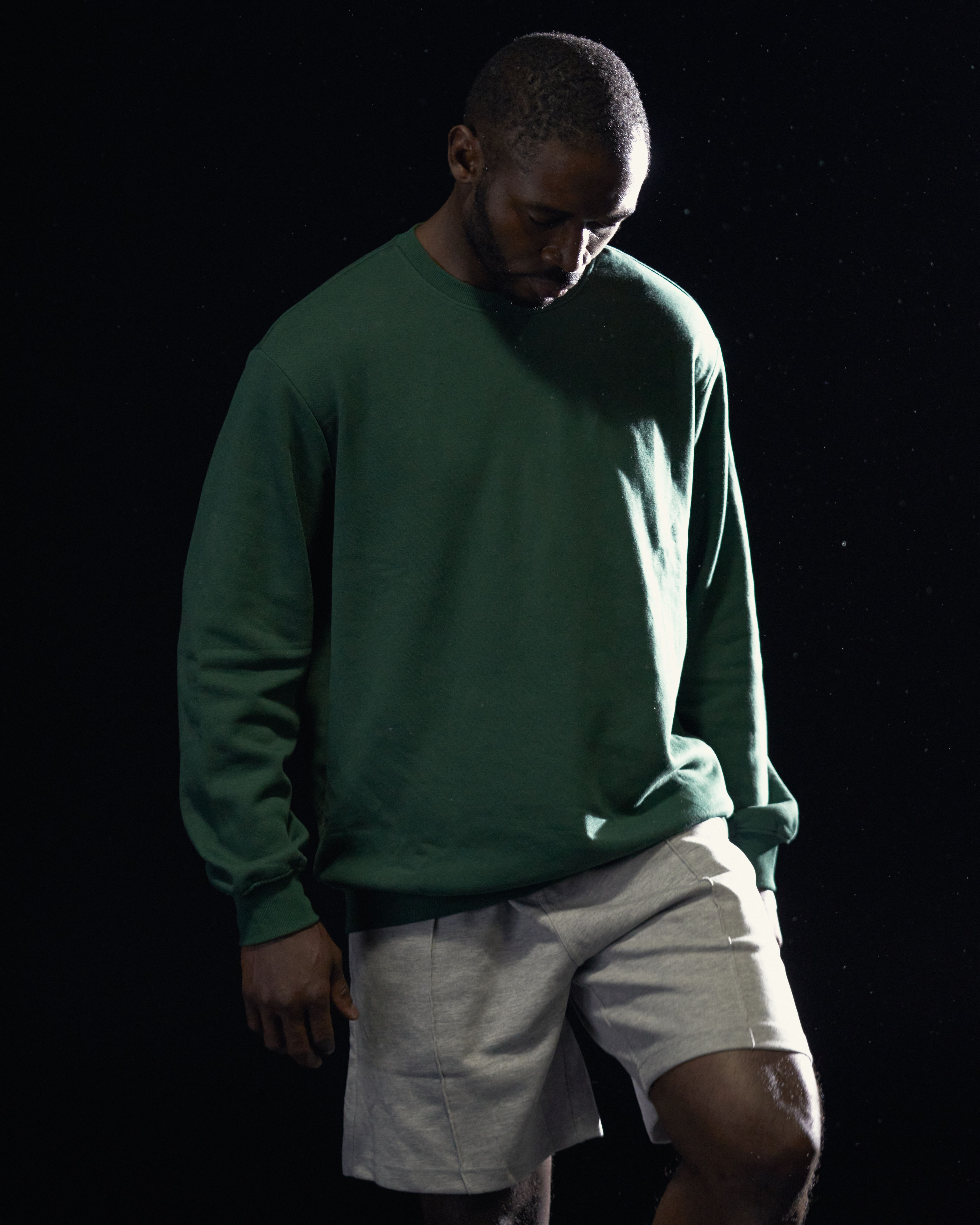 Man Wearing a Hoodie Sweater Standing on a Parking Lot · Free Stock Photo