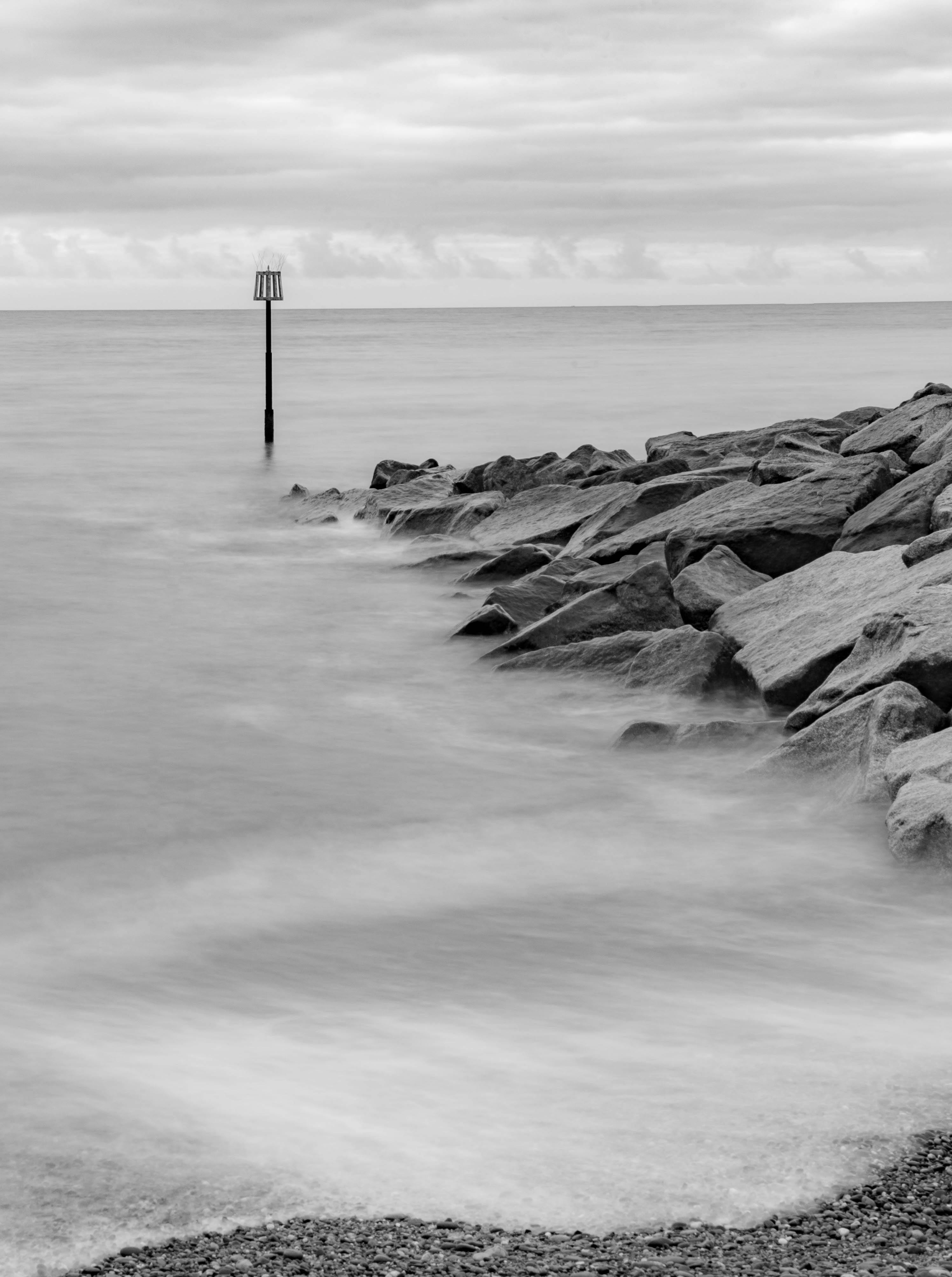 Grayscale Photo of Rocks on Beach · Free Stock Photo