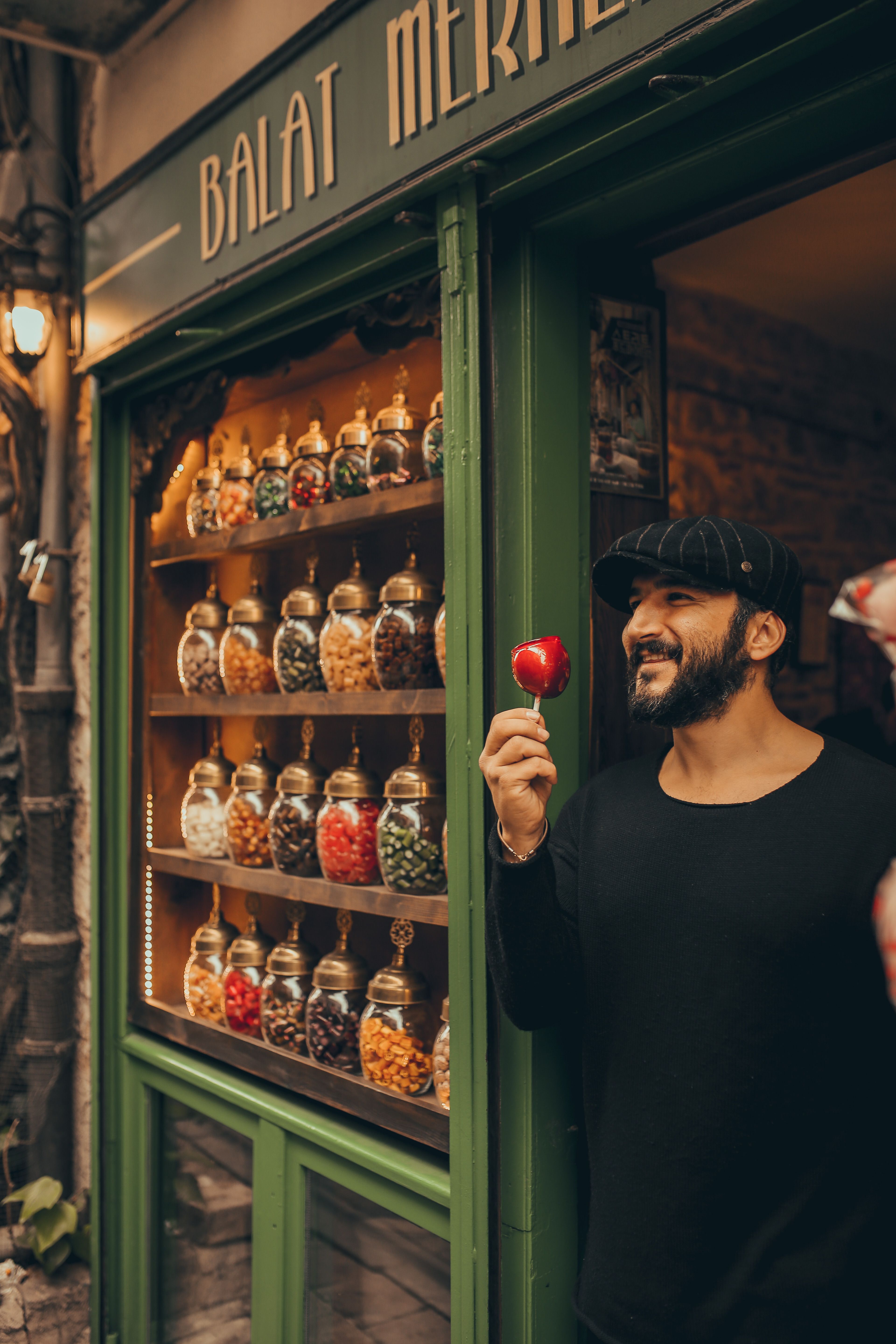 Brunette Man Standing in an Entrance of a Candy Shop · Free Stock Photo