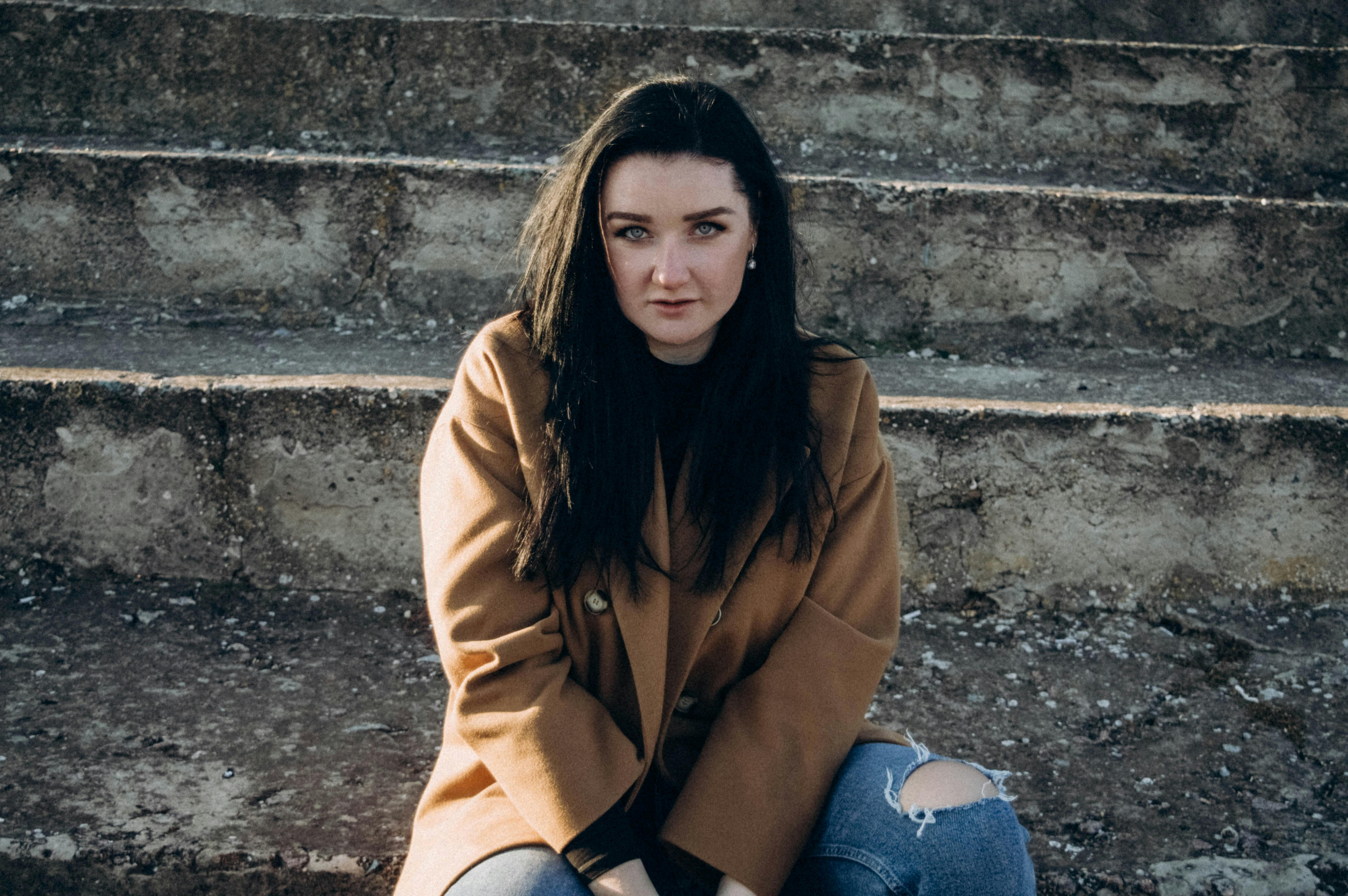 Girl in Brown Coat Holding Pink Flowers · Free Stock Photo