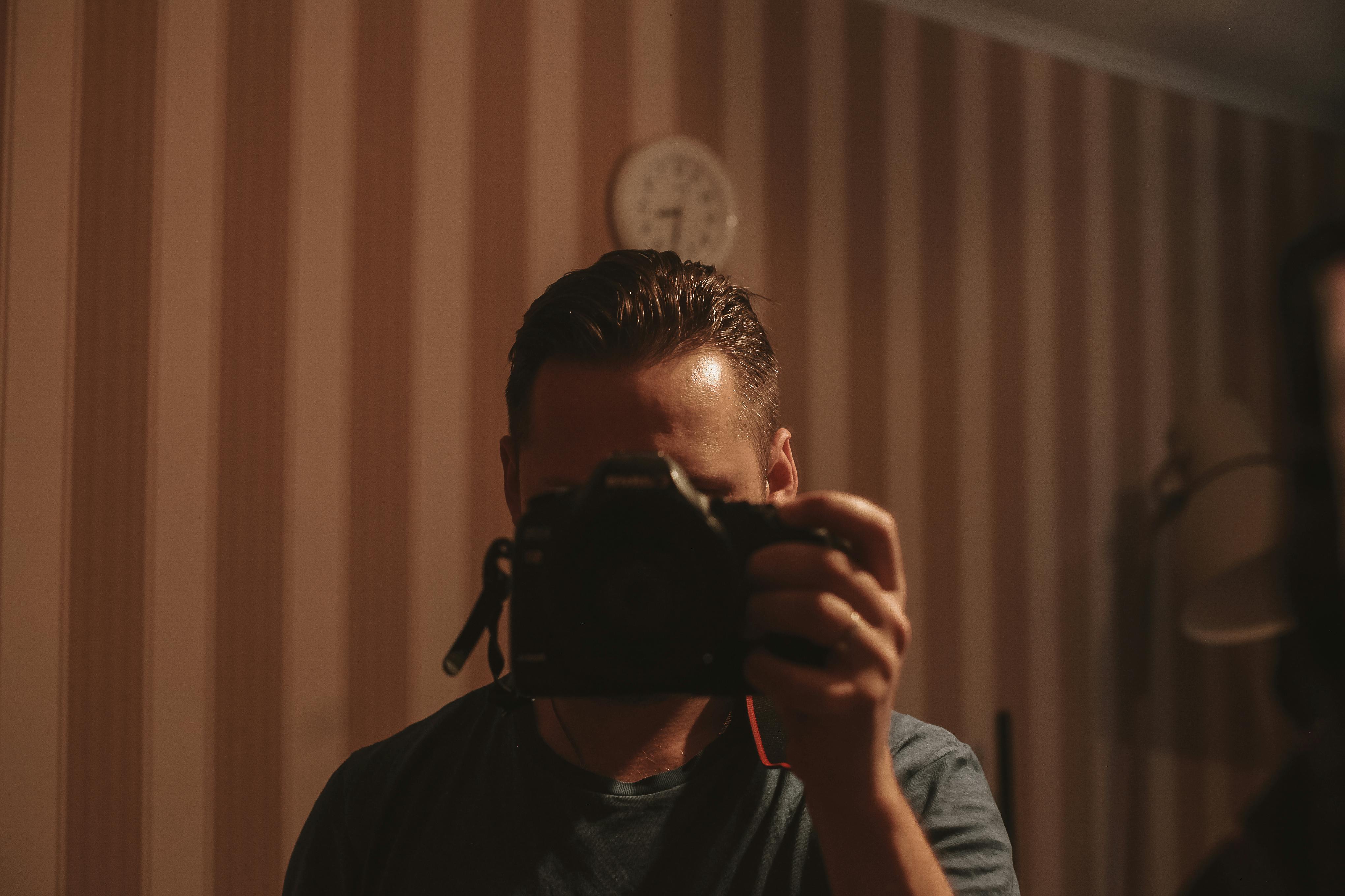 Photo of Man Standing in Alley Holding Dslr Camera Looking at Photos ...