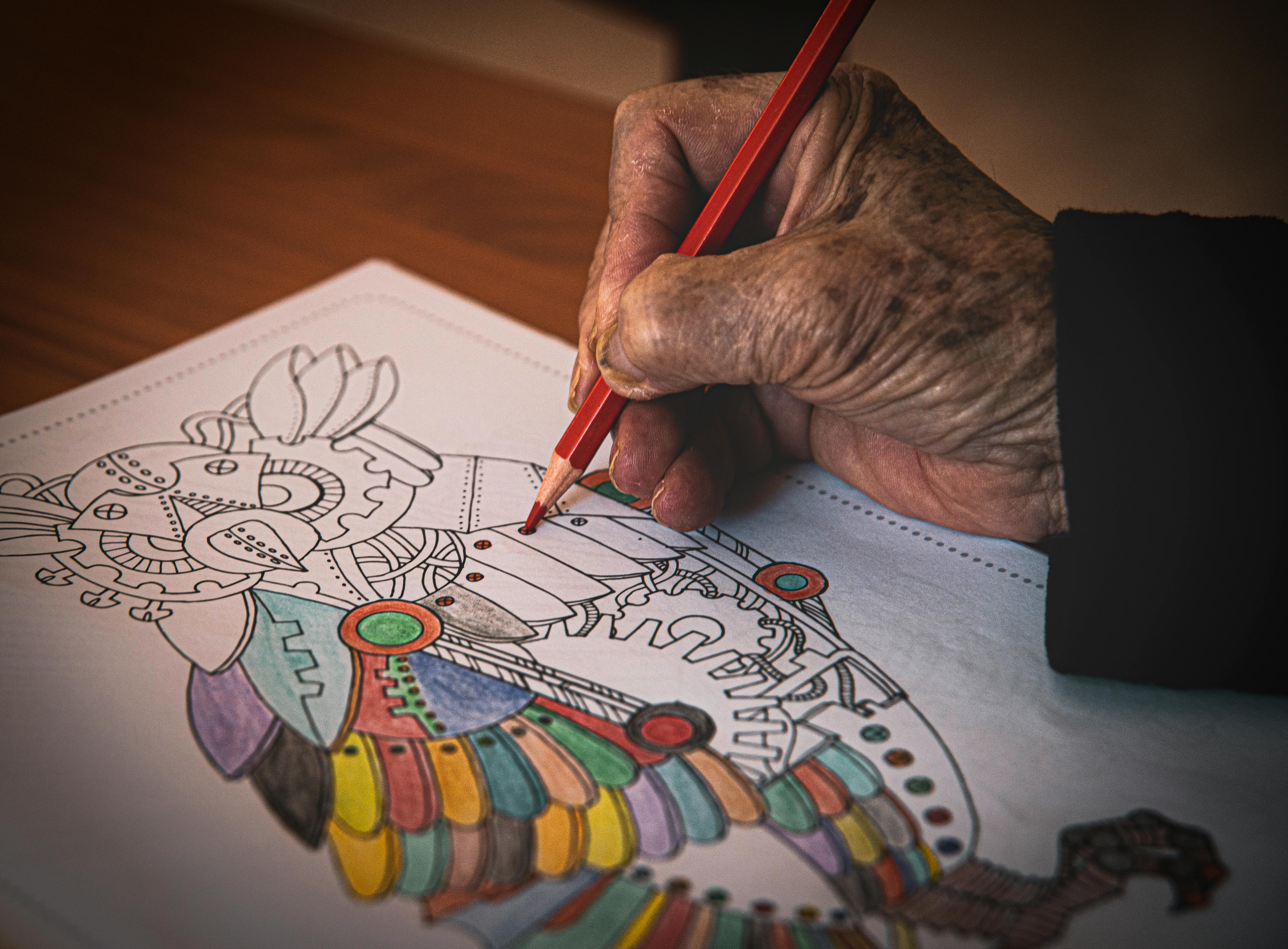 A Person Coloring Using a Red Colored Pencil · Free Stock Photo