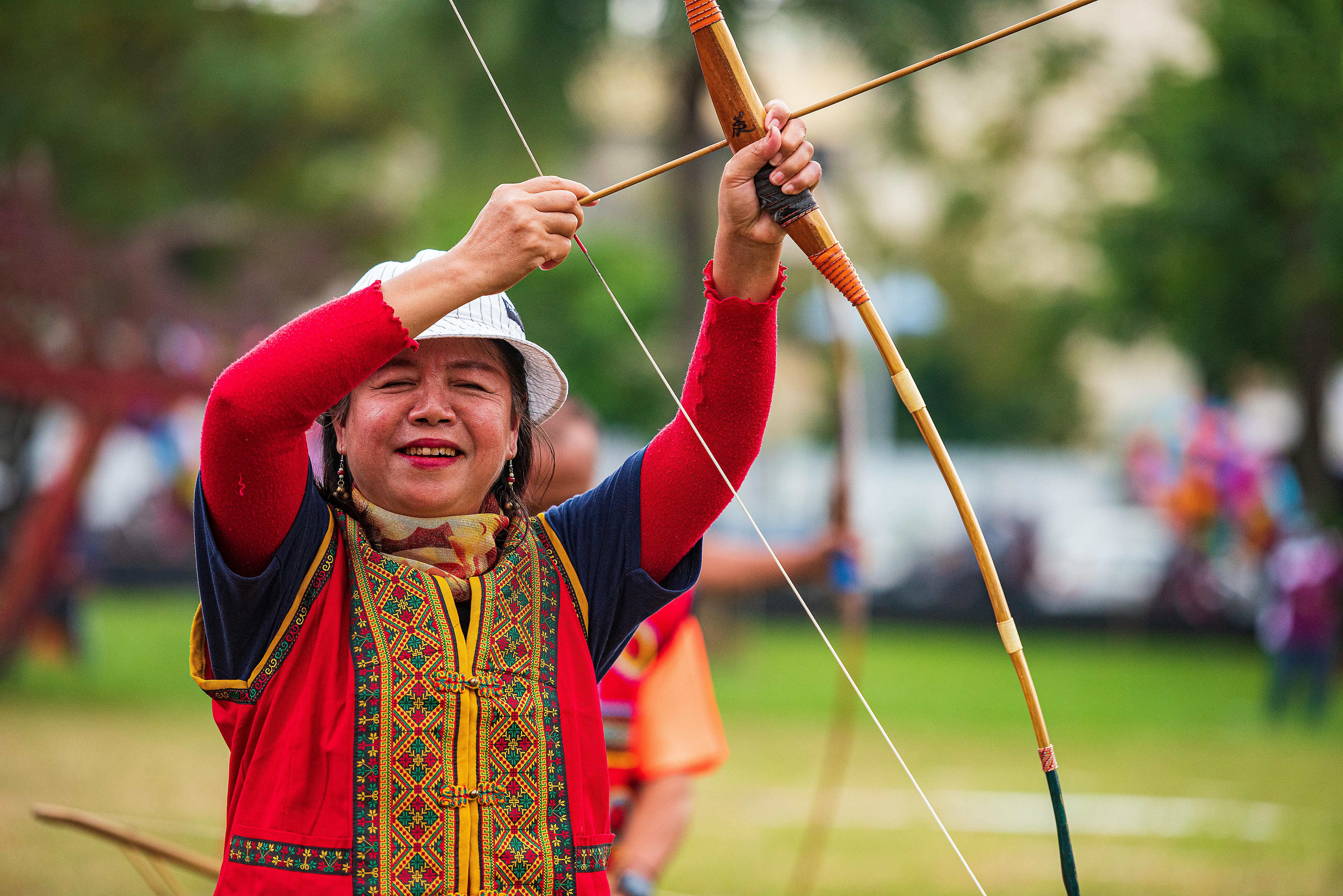 A Woman Holding a Bow and Arrow with her Eyes Closed · Free Stock Photo