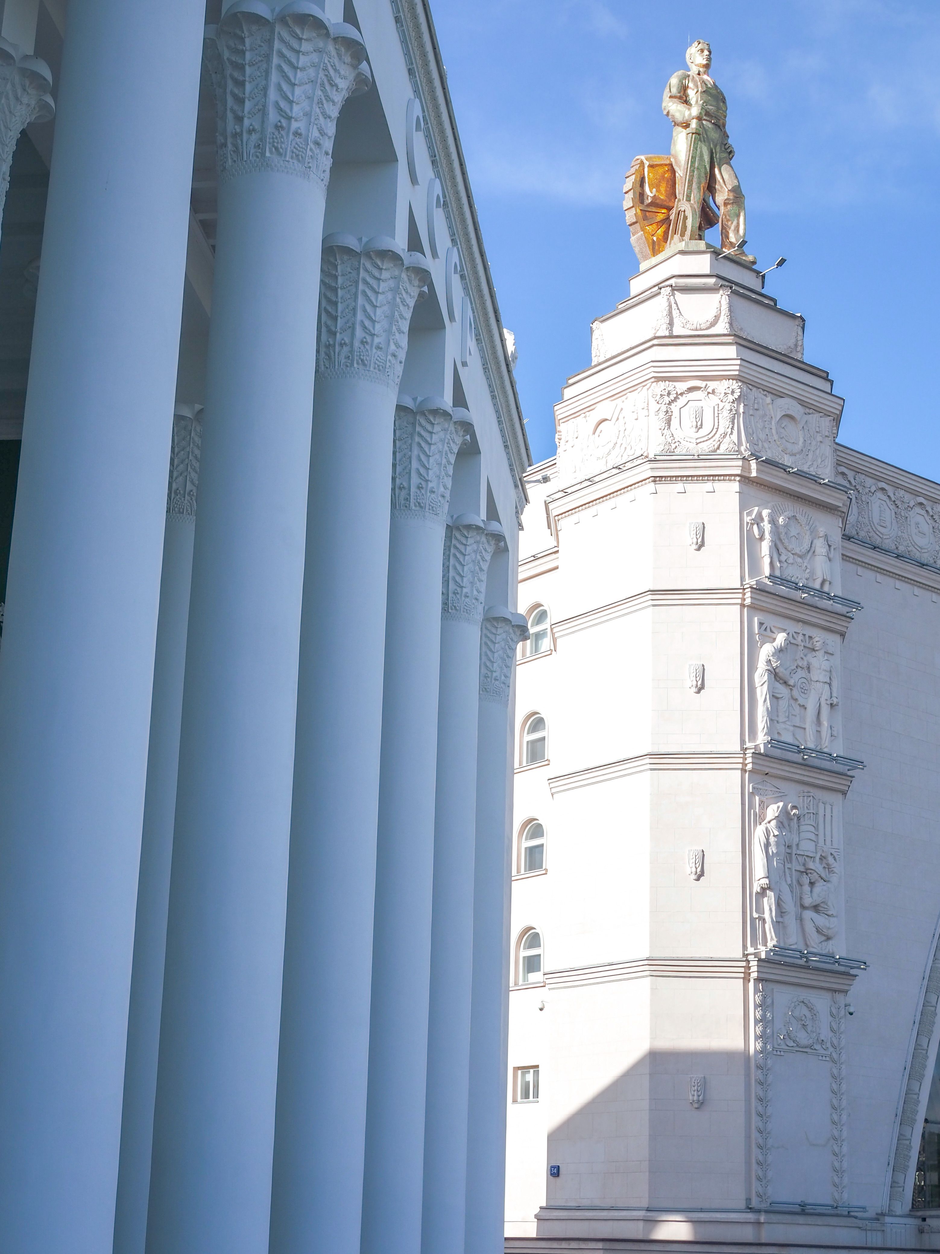 Gold Statue on Top of a White Concrete Building · Free Stock Photo
