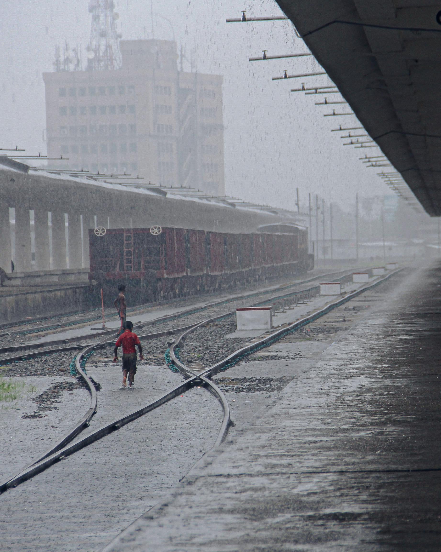 A Person Standing on Train Station While Raining · Free Stock Photo