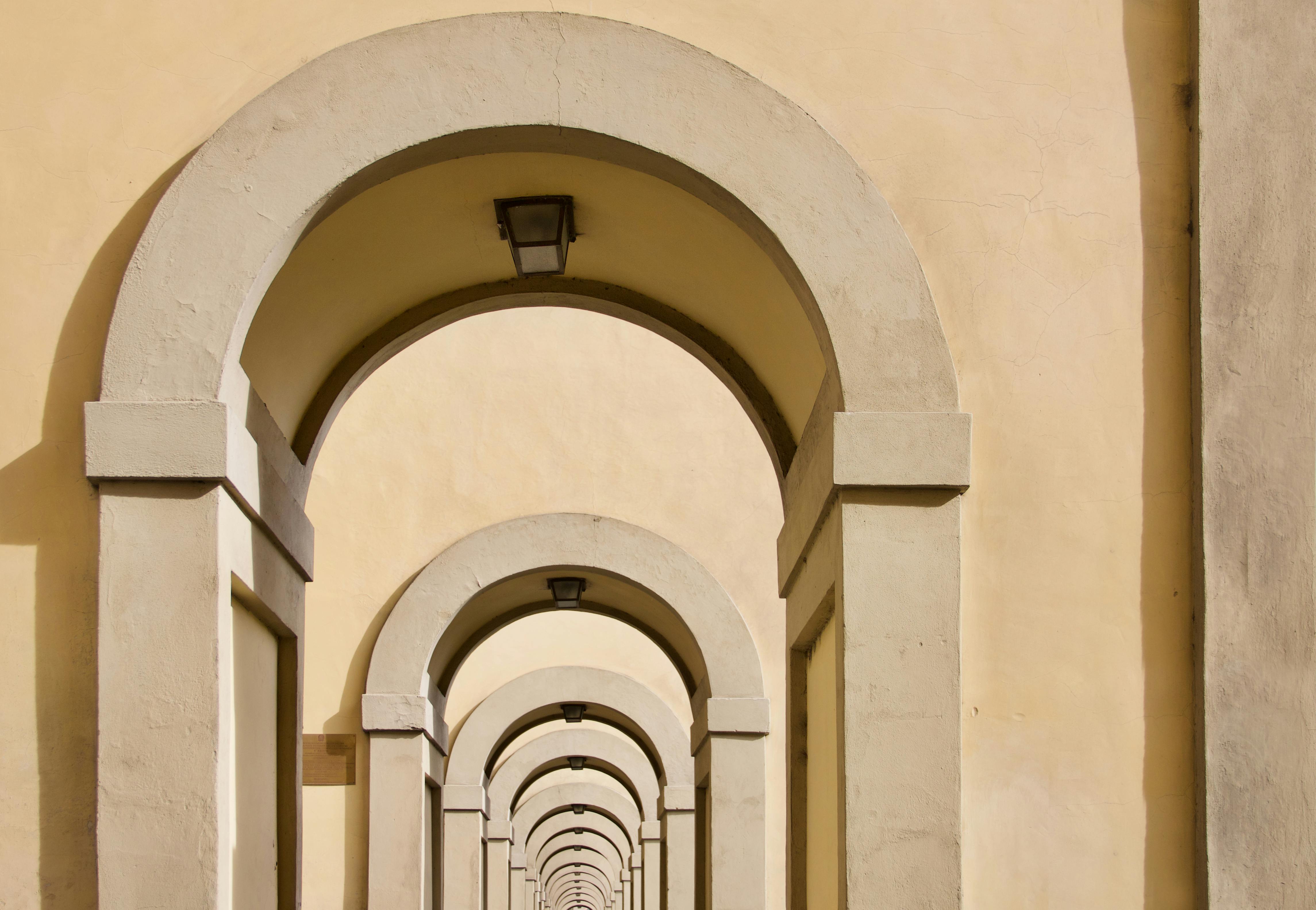 A Series of Concrete Arches in a Beige Building · Free Stock Photo