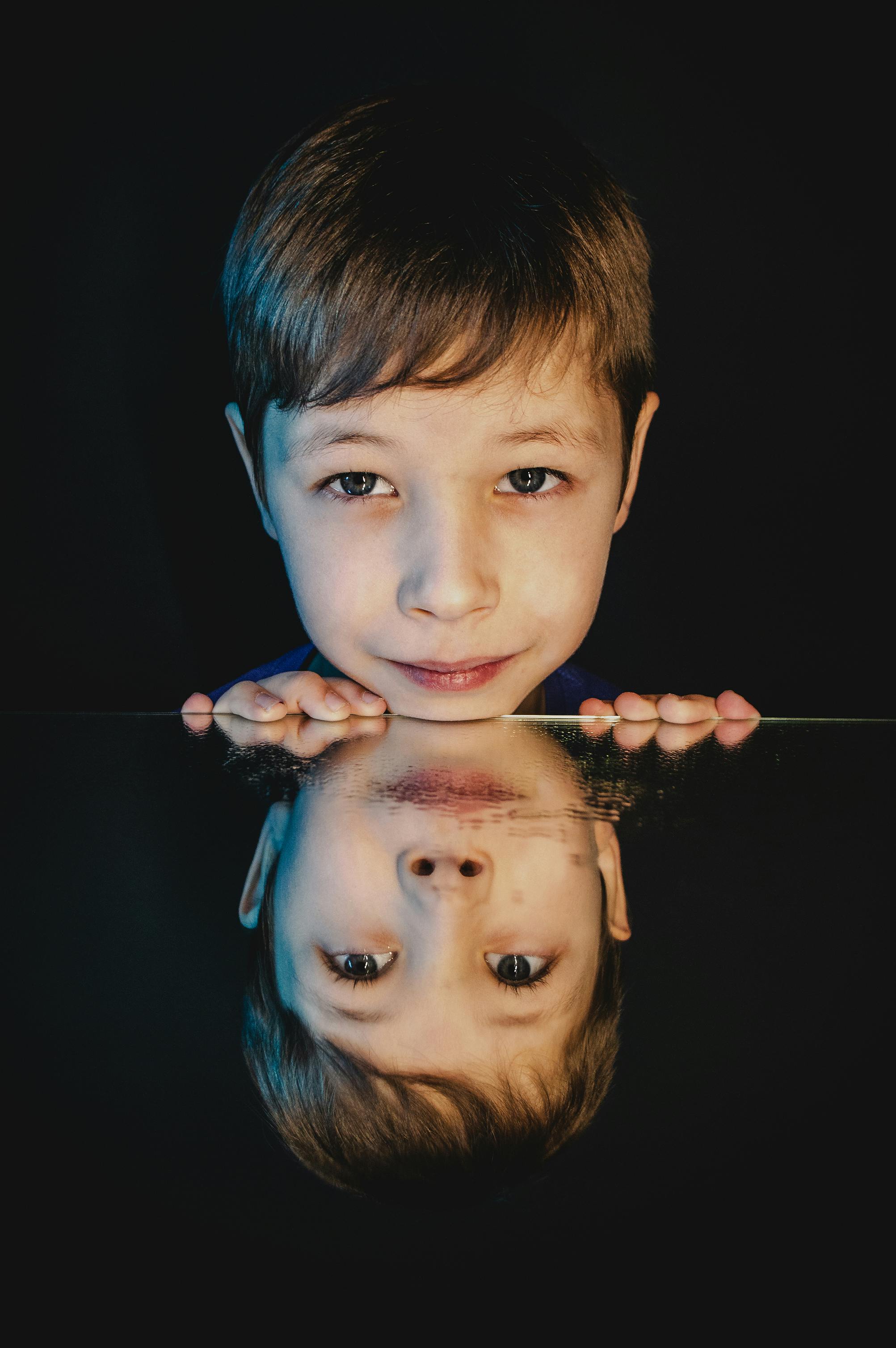 A Kid in Gray Sweater with Reflection on Glass Table · Free Stock Photo
