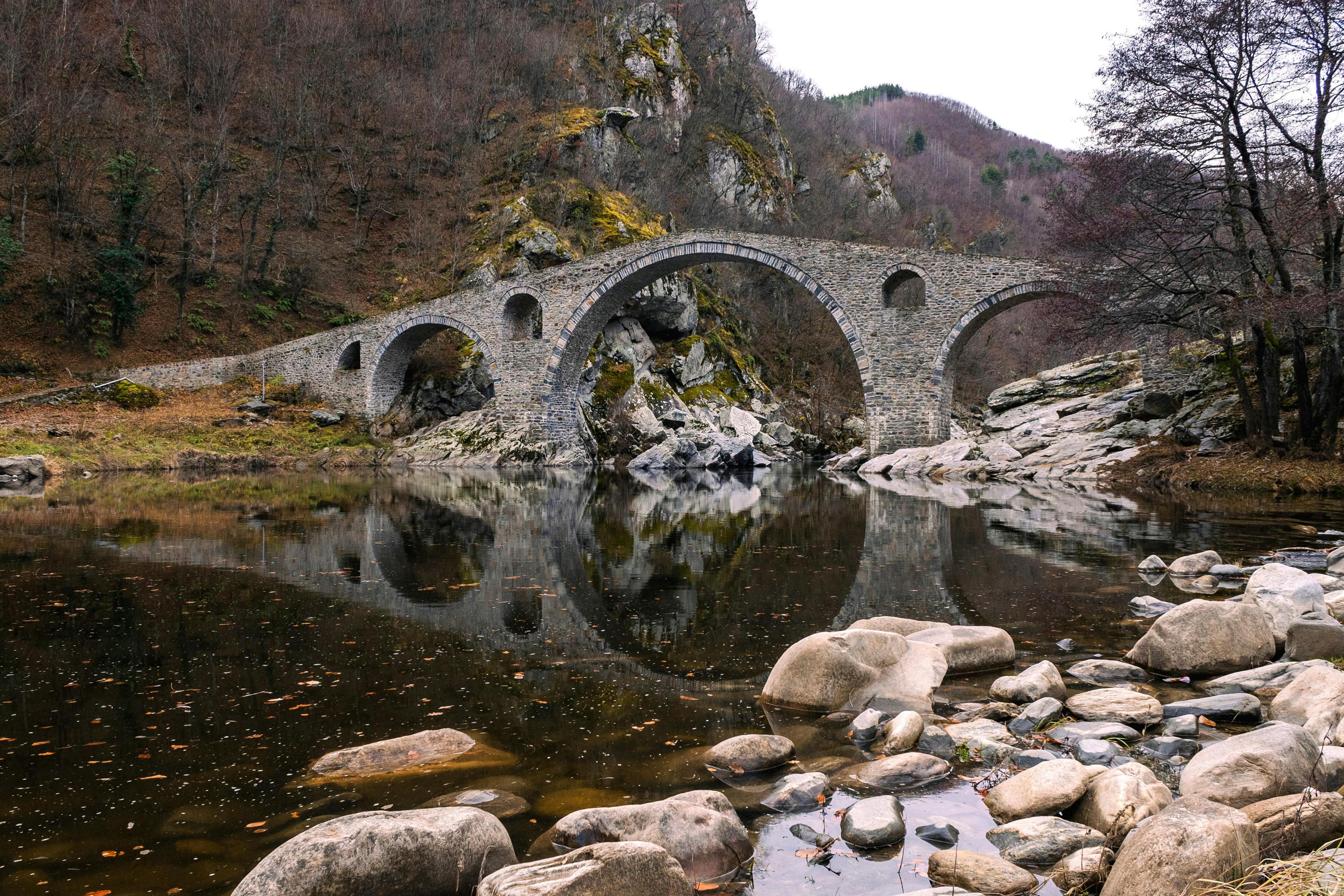 Bridge in a Valley and Stones in a River · Free Stock Photo