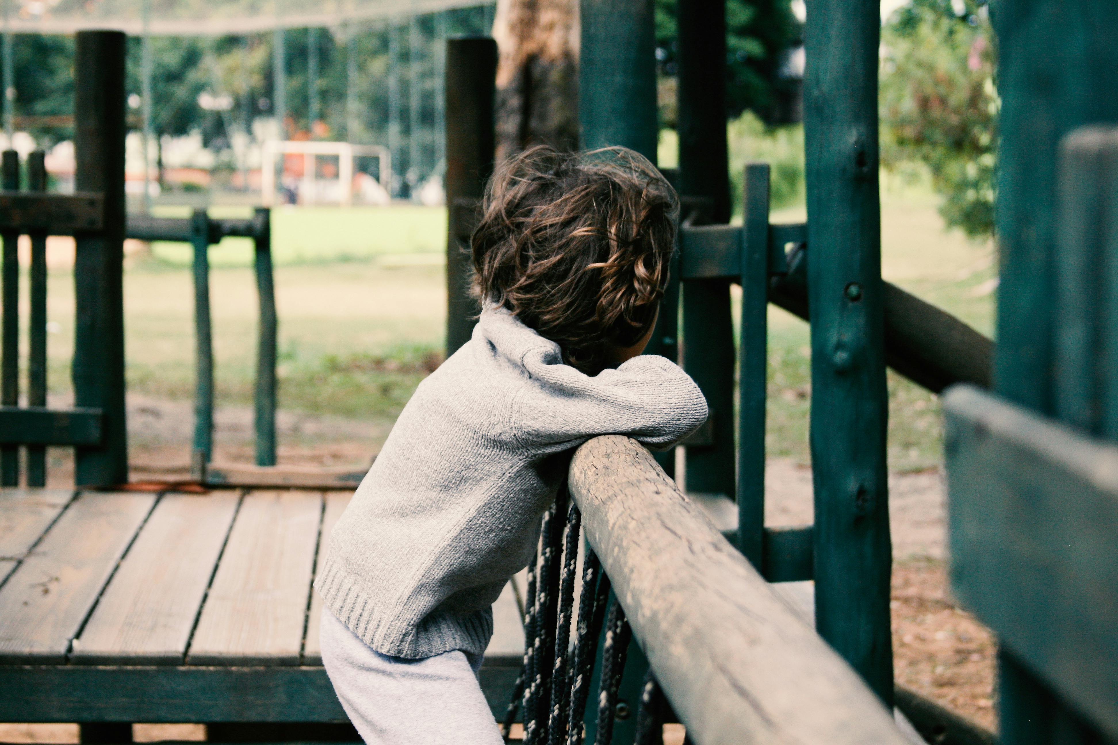 Cute little kid leaning on log while resting on rocky coast · Free ...