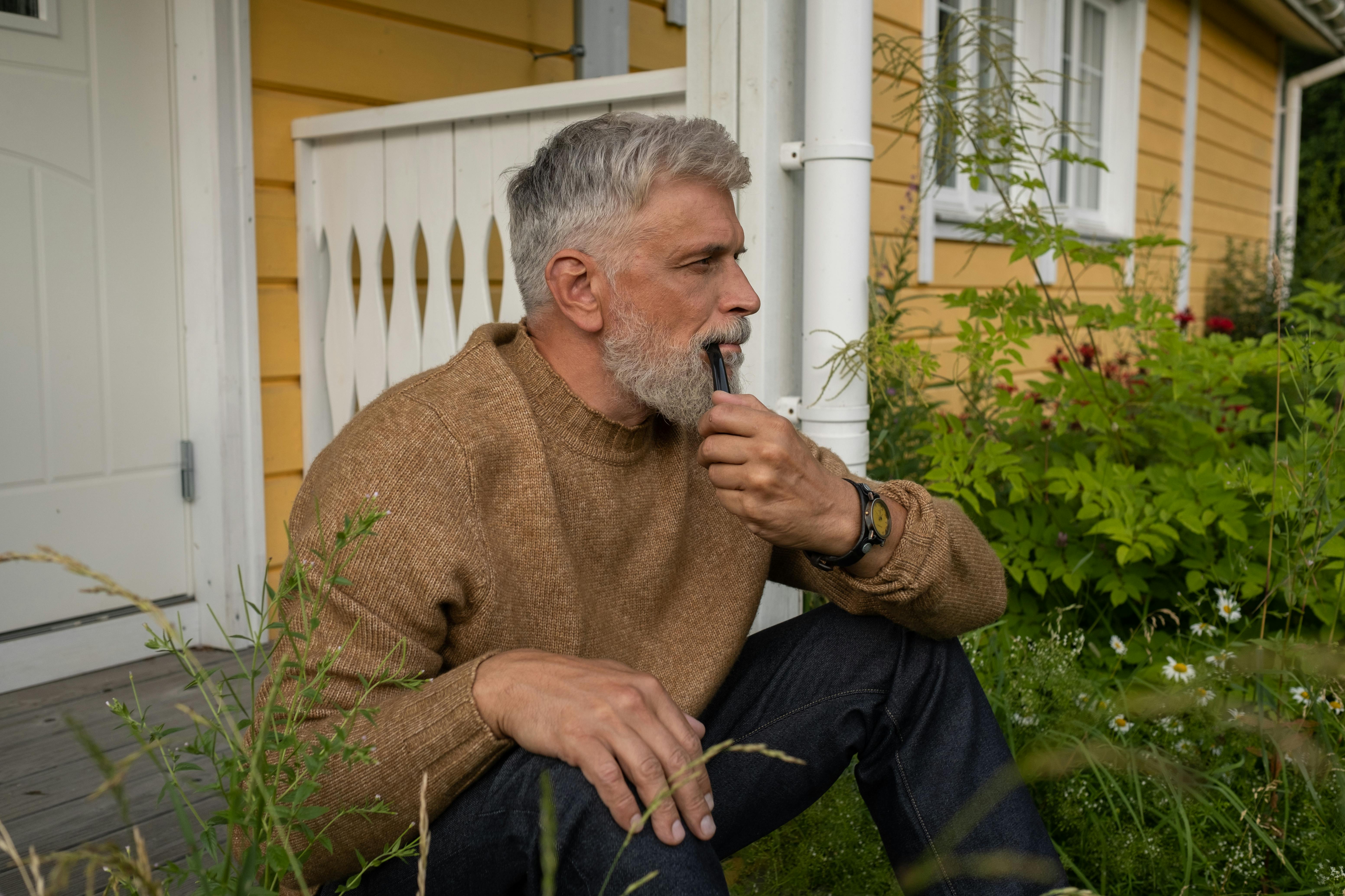 Elderly Man Sitting On Porch with Pipe · Free Stock Photo