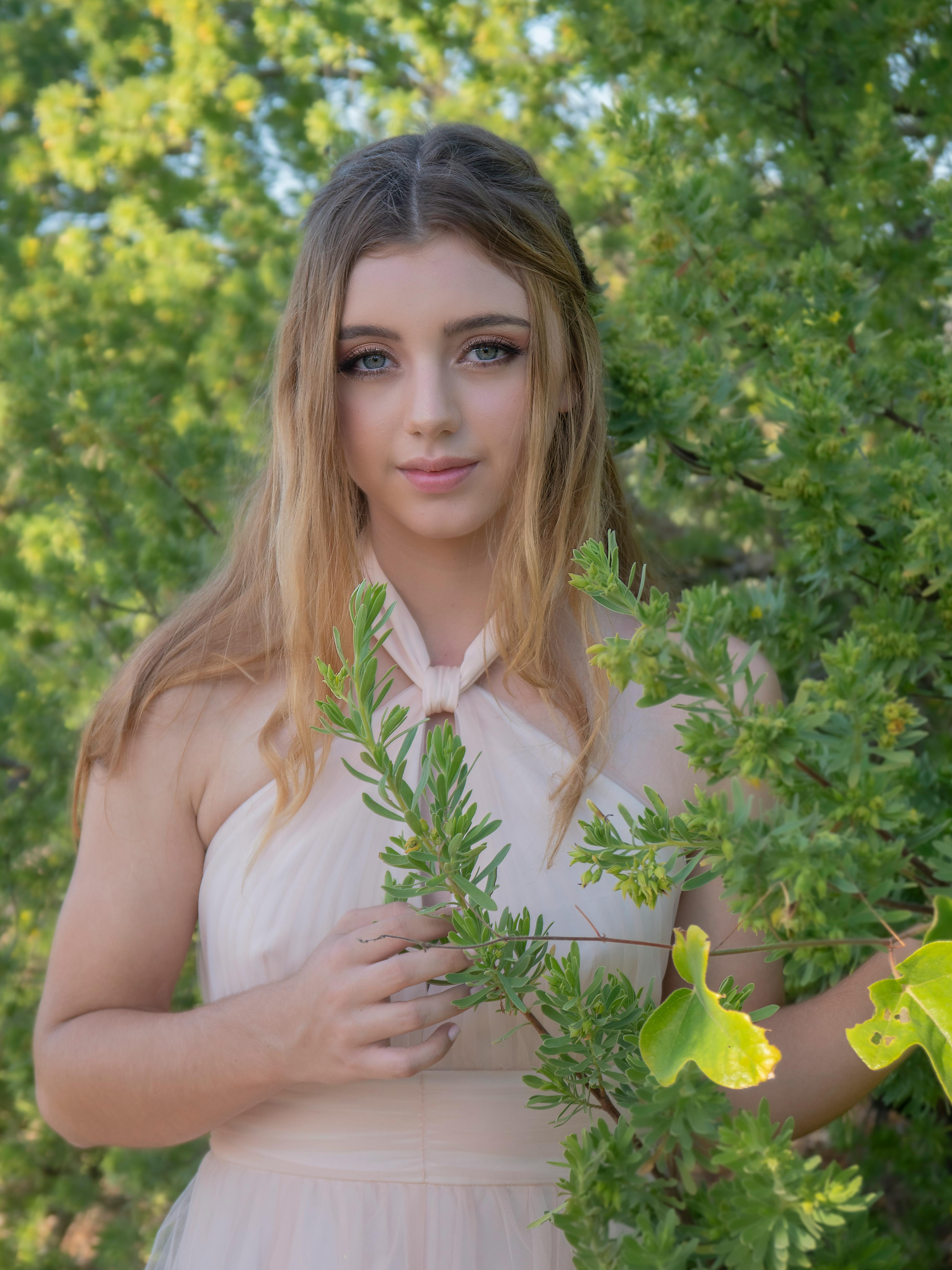Beautiful Woman Posing near Green Plants · Free Stock Photo