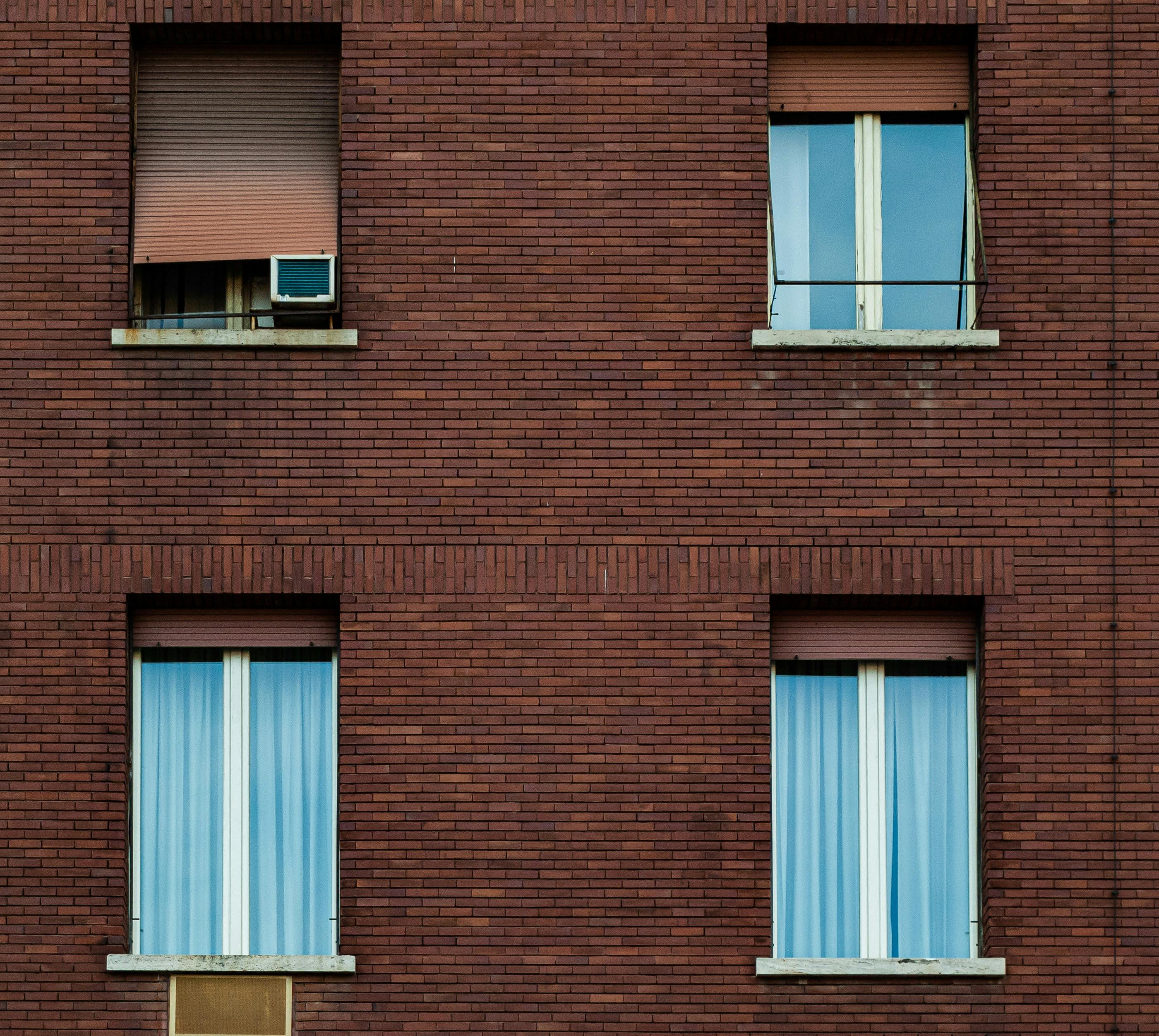 Brown Brick Building With White Window Blinds · Free Stock Photo