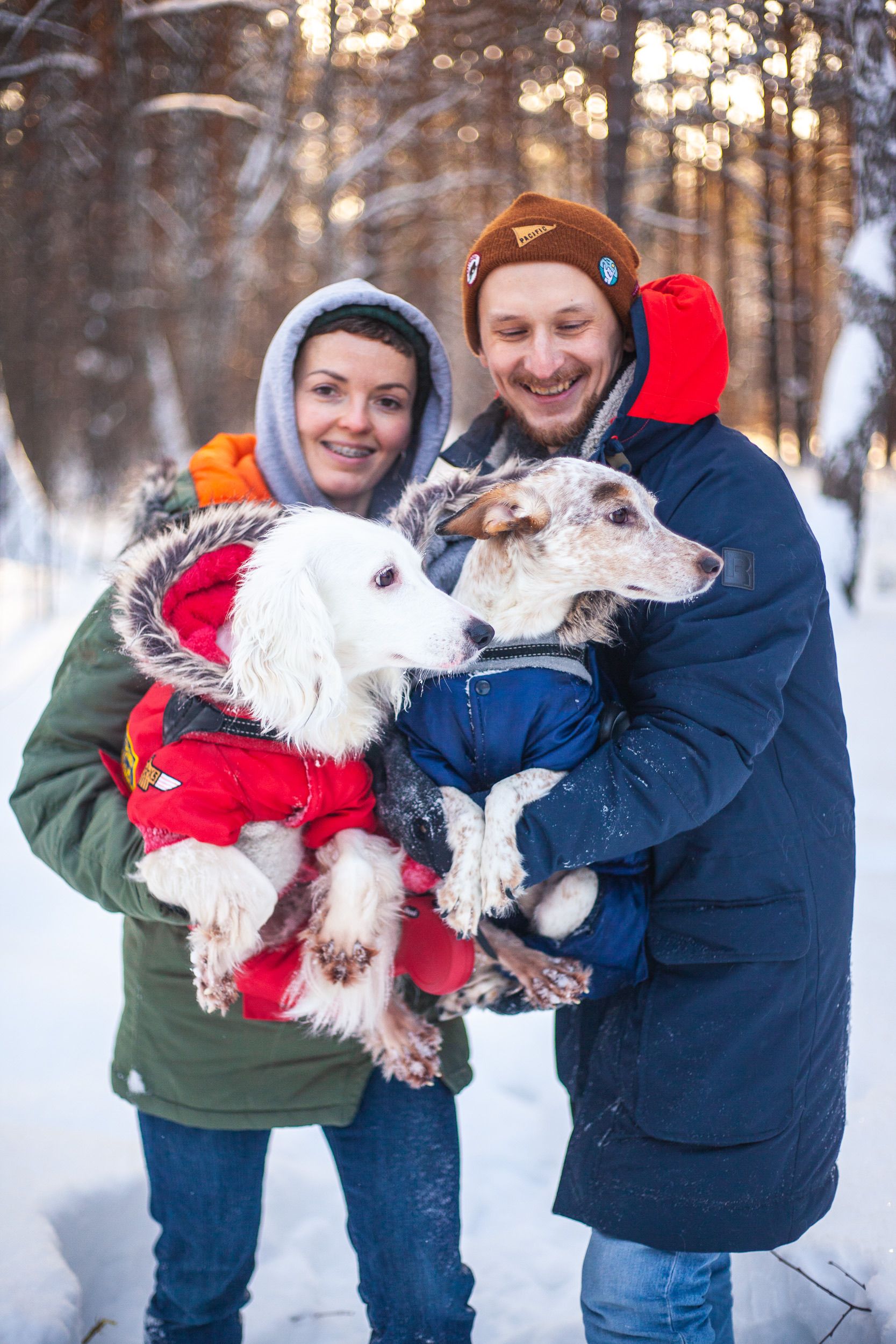 Smiling Woman Carrying Dog Near Tree · Free Stock Photo