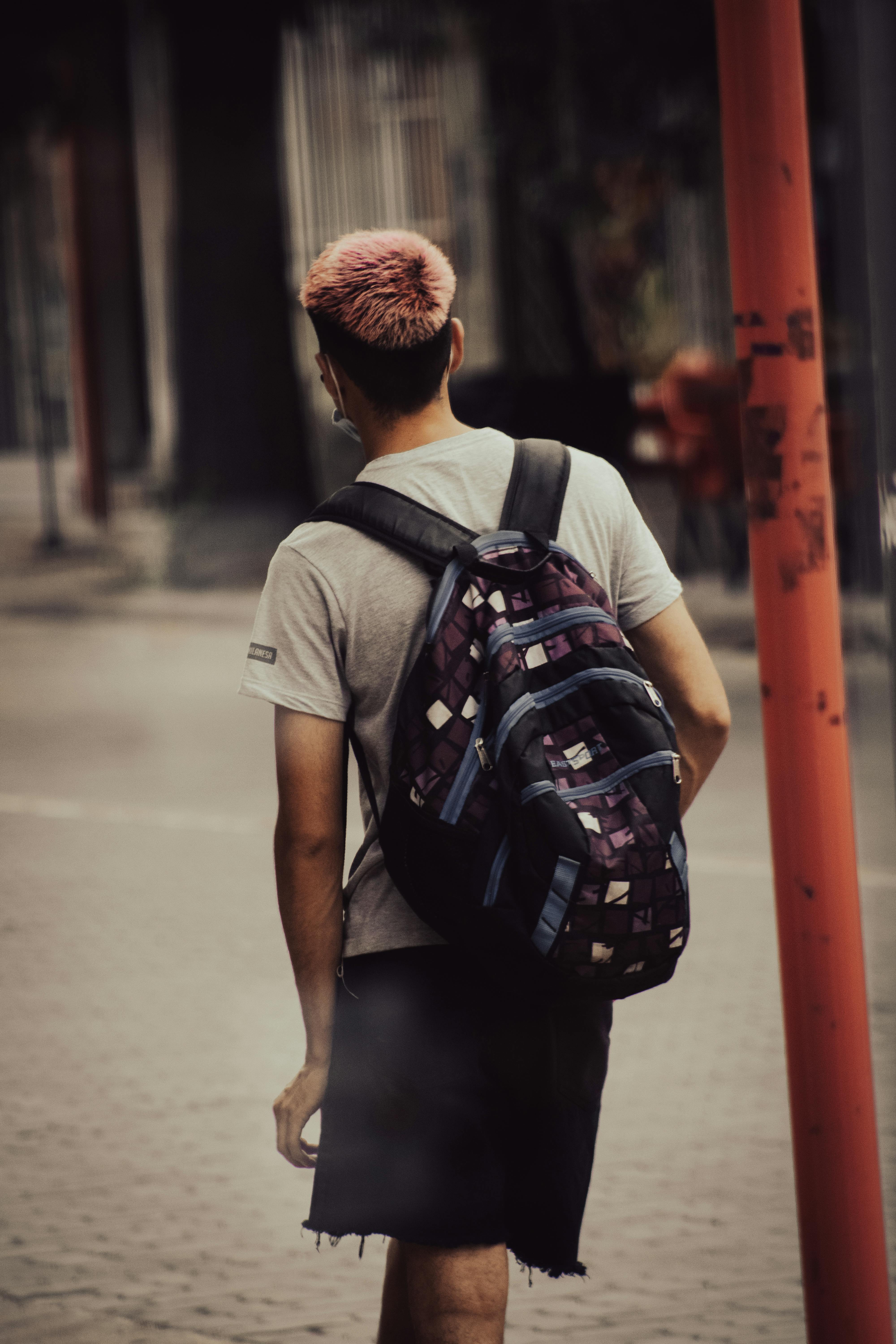 Back View of a Man Walking on Wet Pavement with His Luggage · Free ...