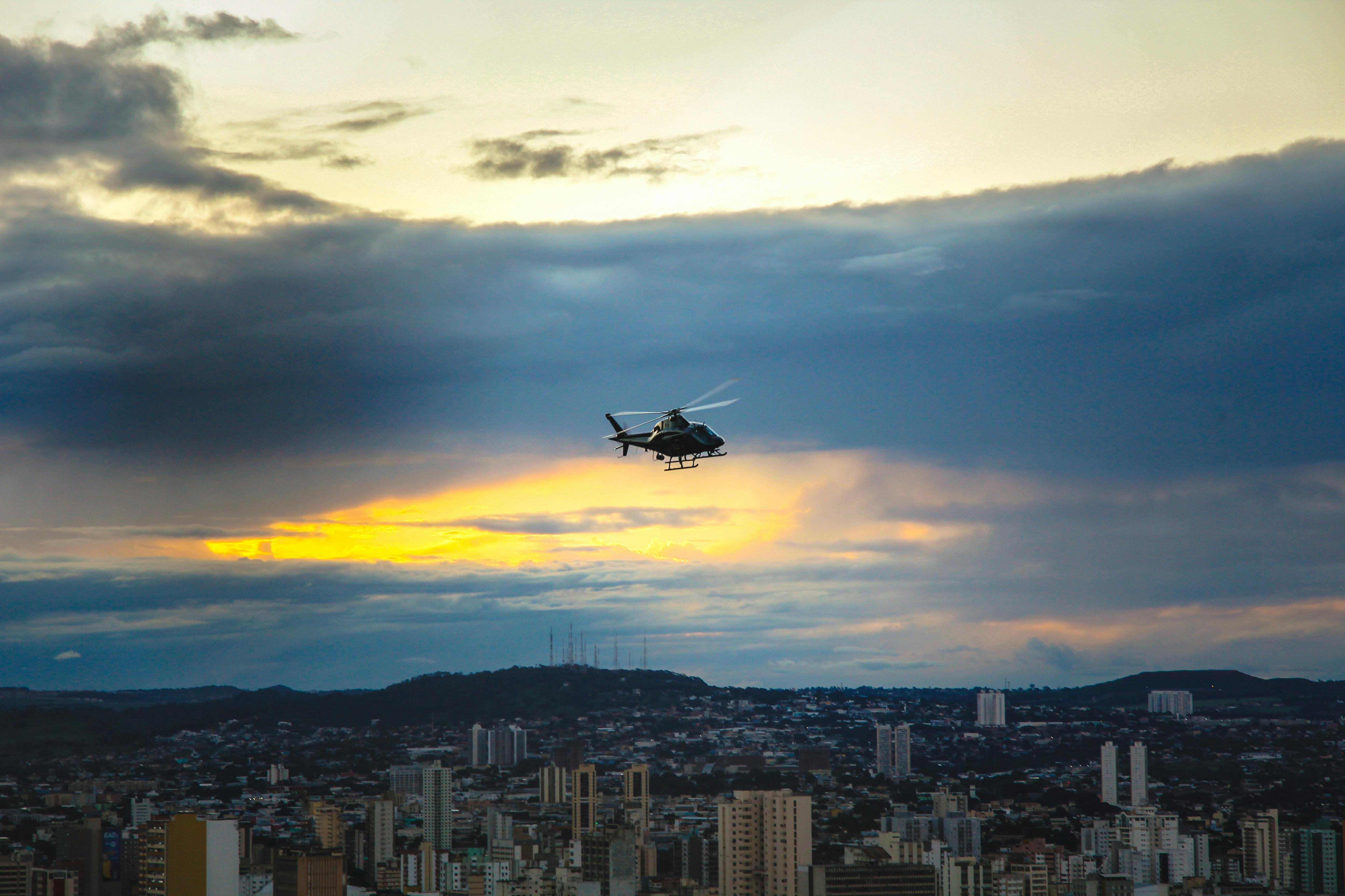 A Helicopter Flying over City during Sunset · Free Stock Photo