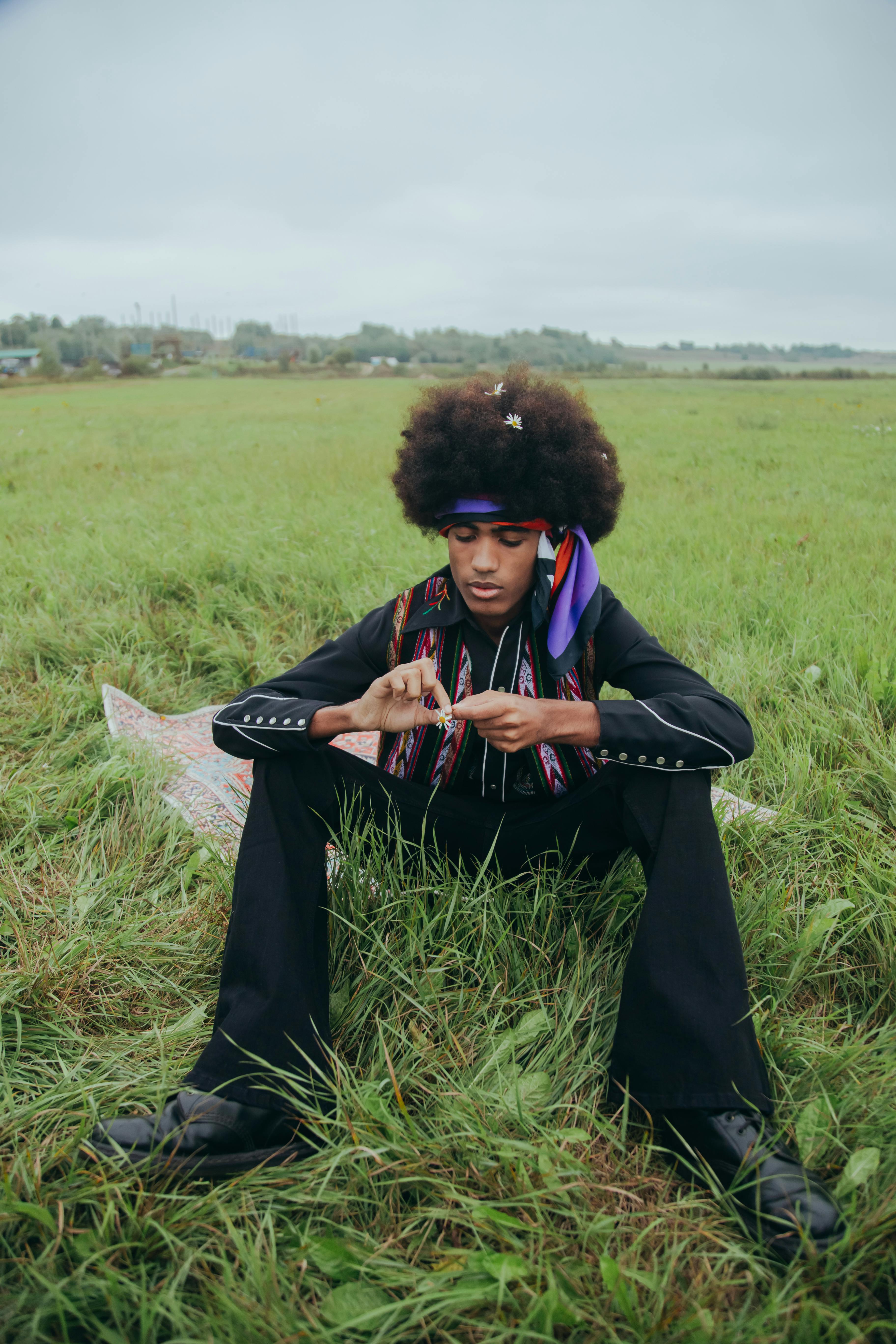 Man With Afro Hair Standing on Grass Field · Free Stock Photo