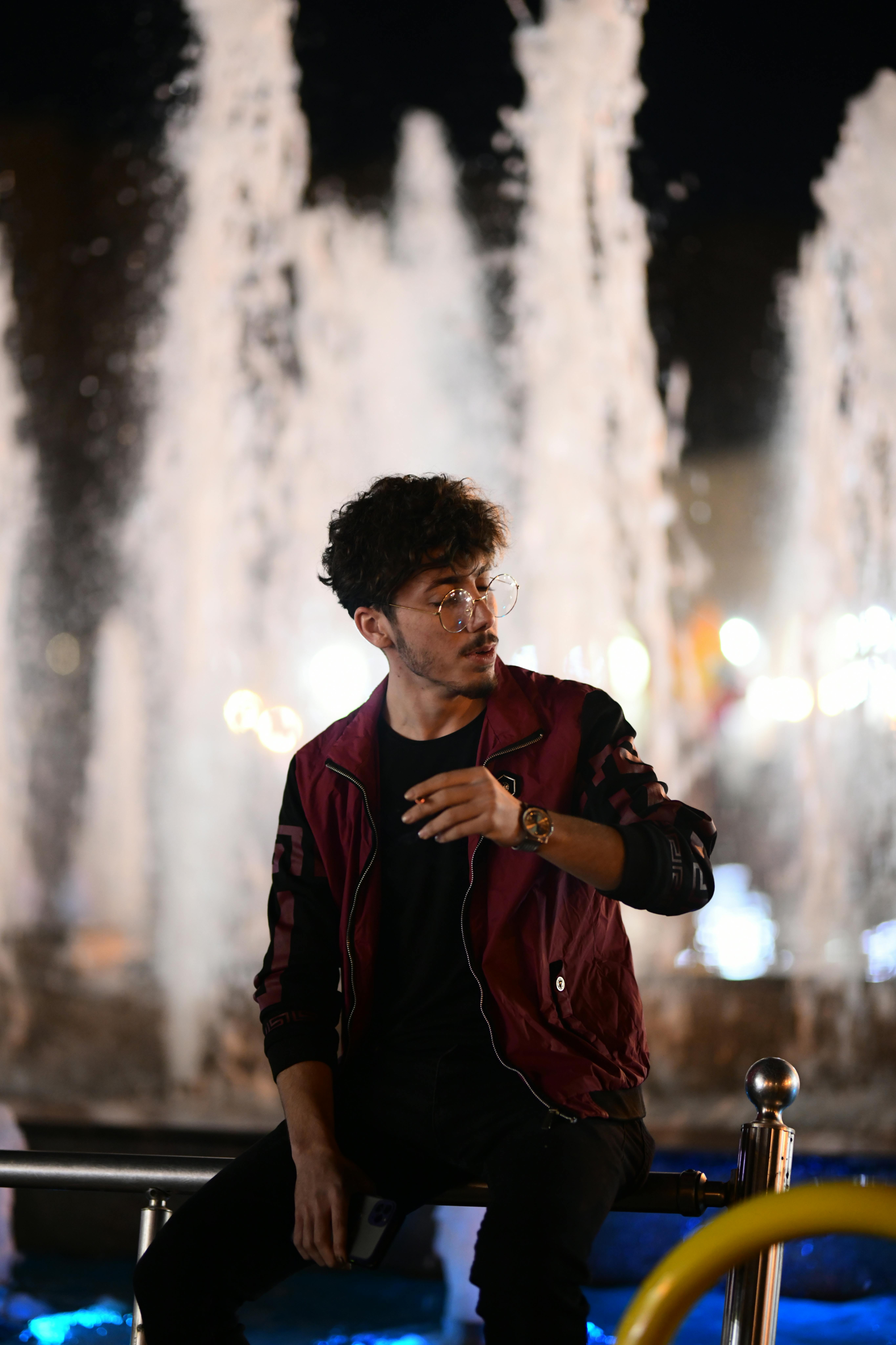 Man Sitting on the Railing Smoking a Cigarette · Free Stock Photo