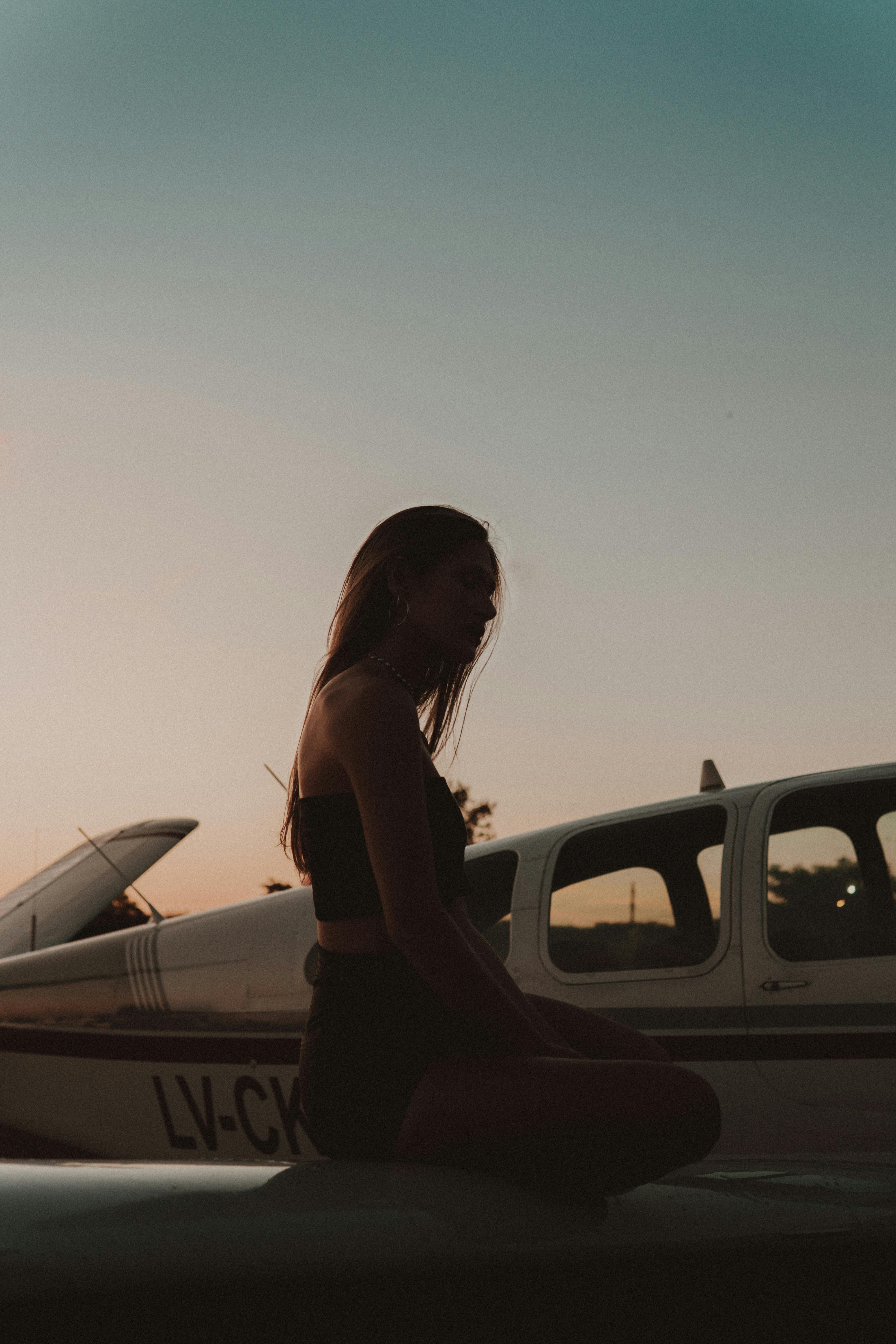 Woman Sitting on a Light Aircraft's Wing · Free Stock Photo