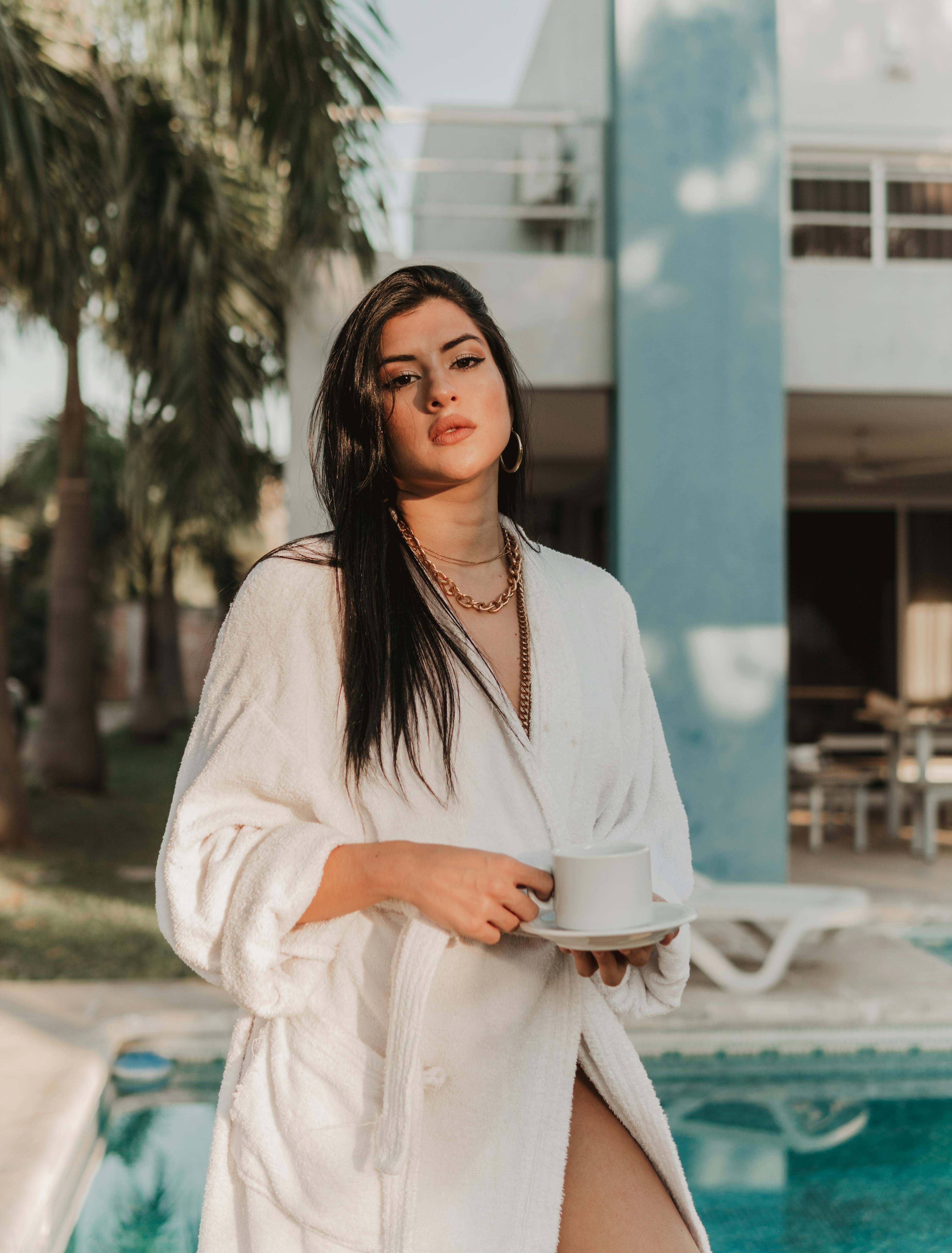 Person Steps on Rocks Wearing a Robe and Holding a Hat · Free Stock Photo
