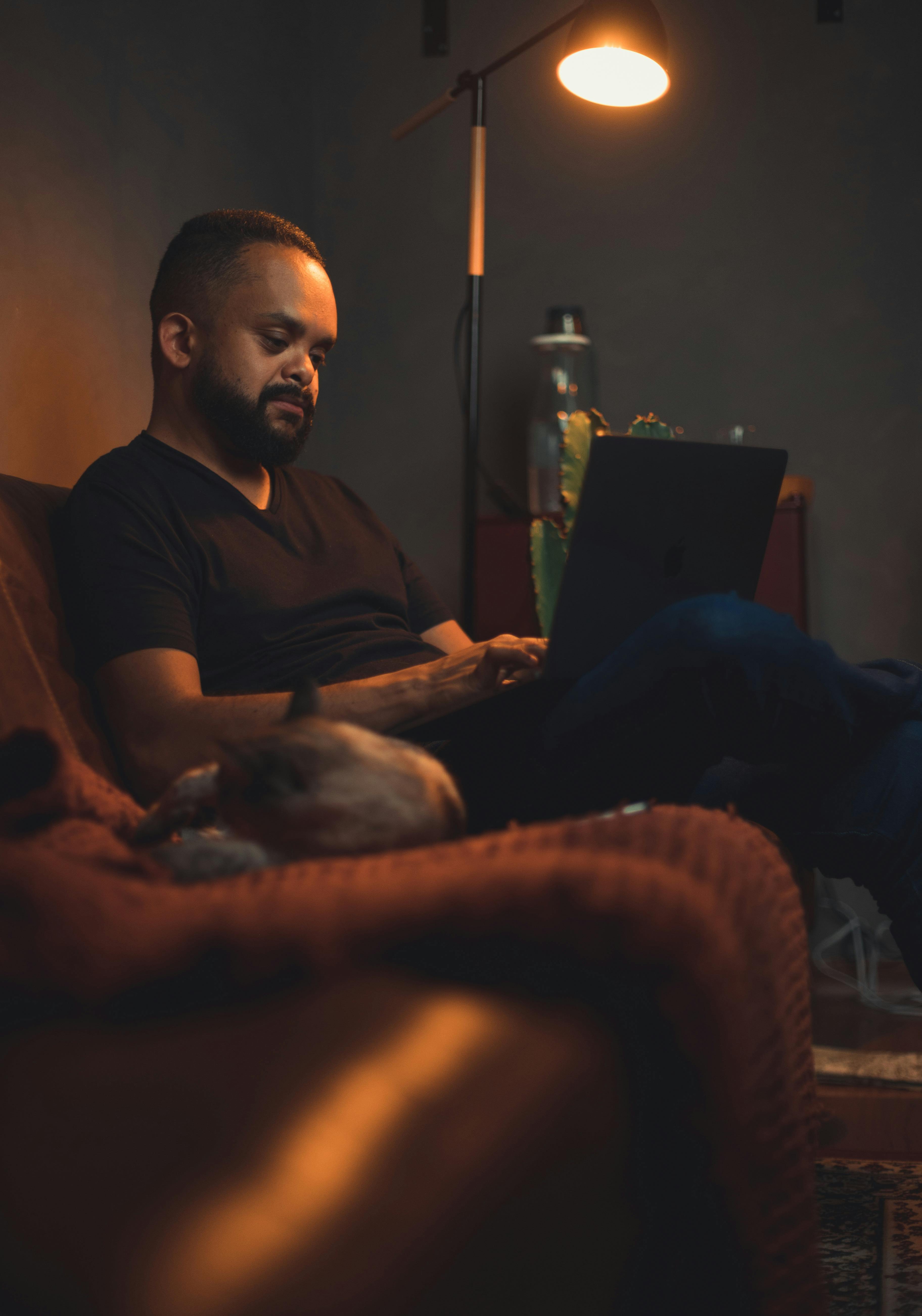 Man Sitting on a Couch Touching his Eyelids · Free Stock Photo