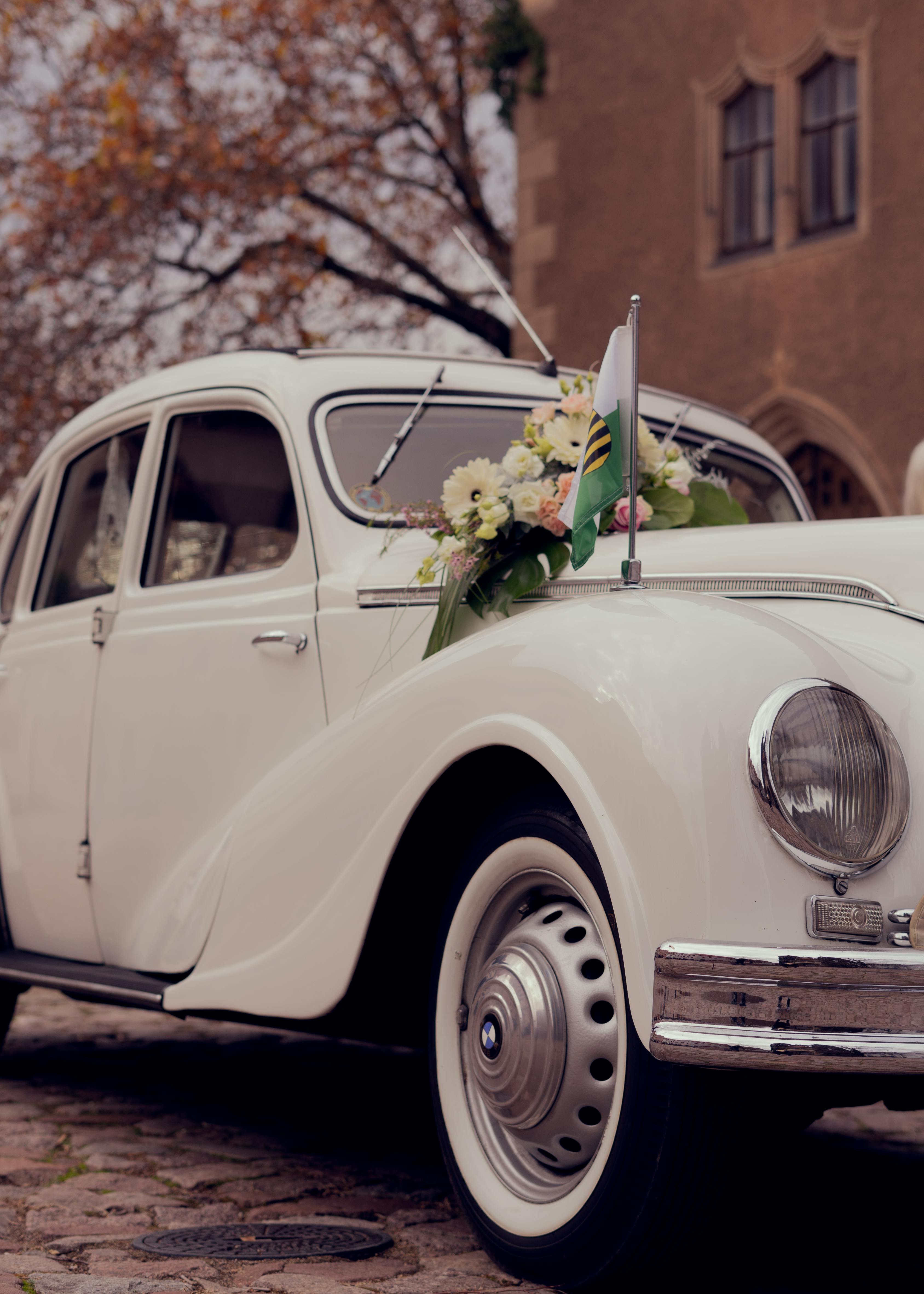 Bouquet of Flowers on Parked White Volkswagen Beetle · Free Stock Photo